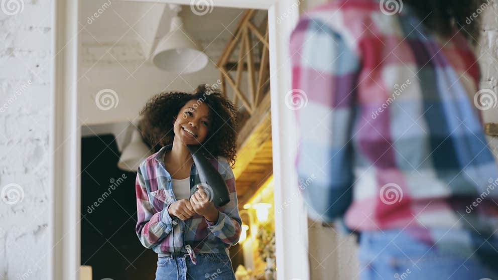 Curly Funny African American Girl Dancing And Singing With Hair Dryer