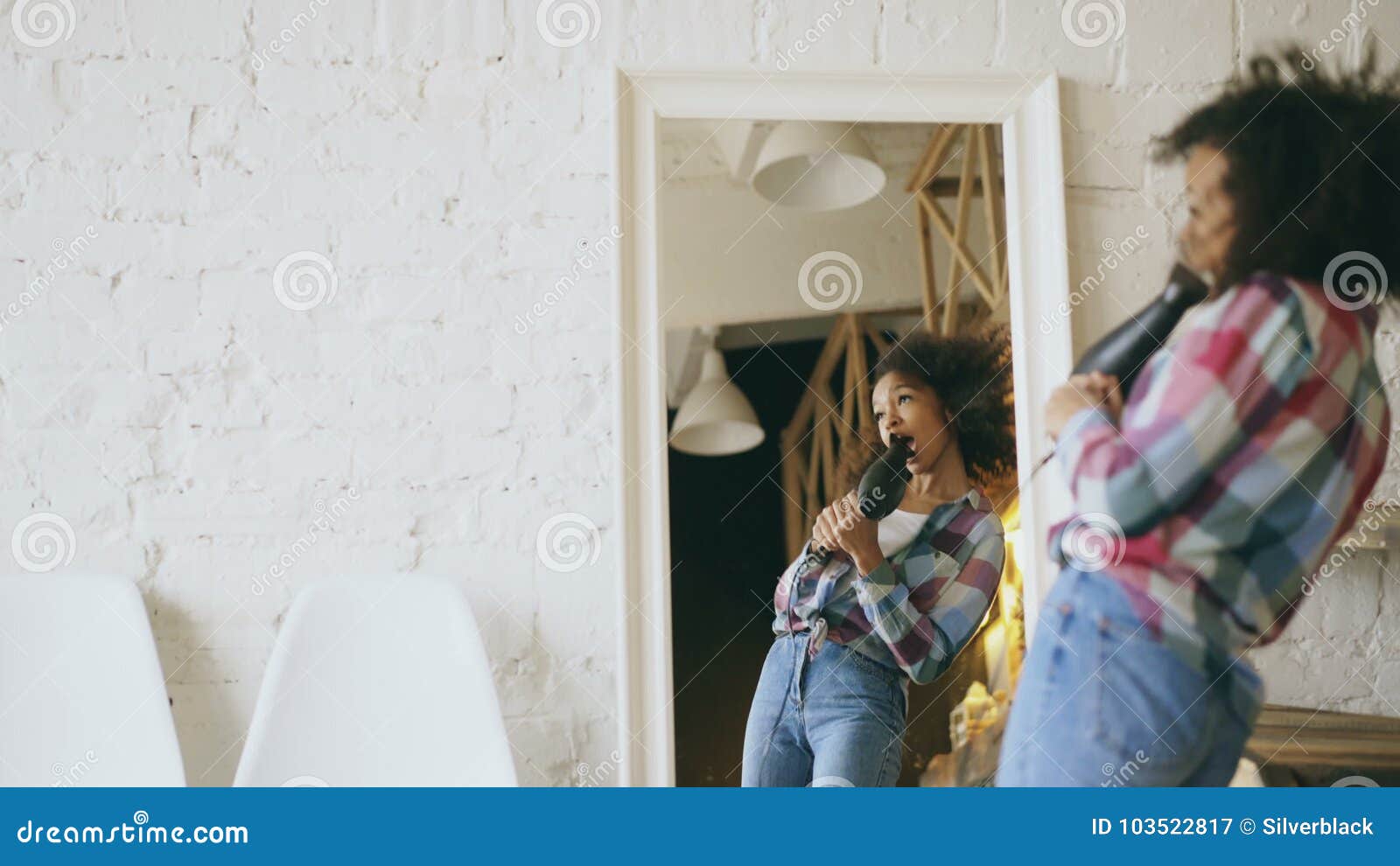 Curly Funny African American Girl Dancing And Singing With Hair Dryer
