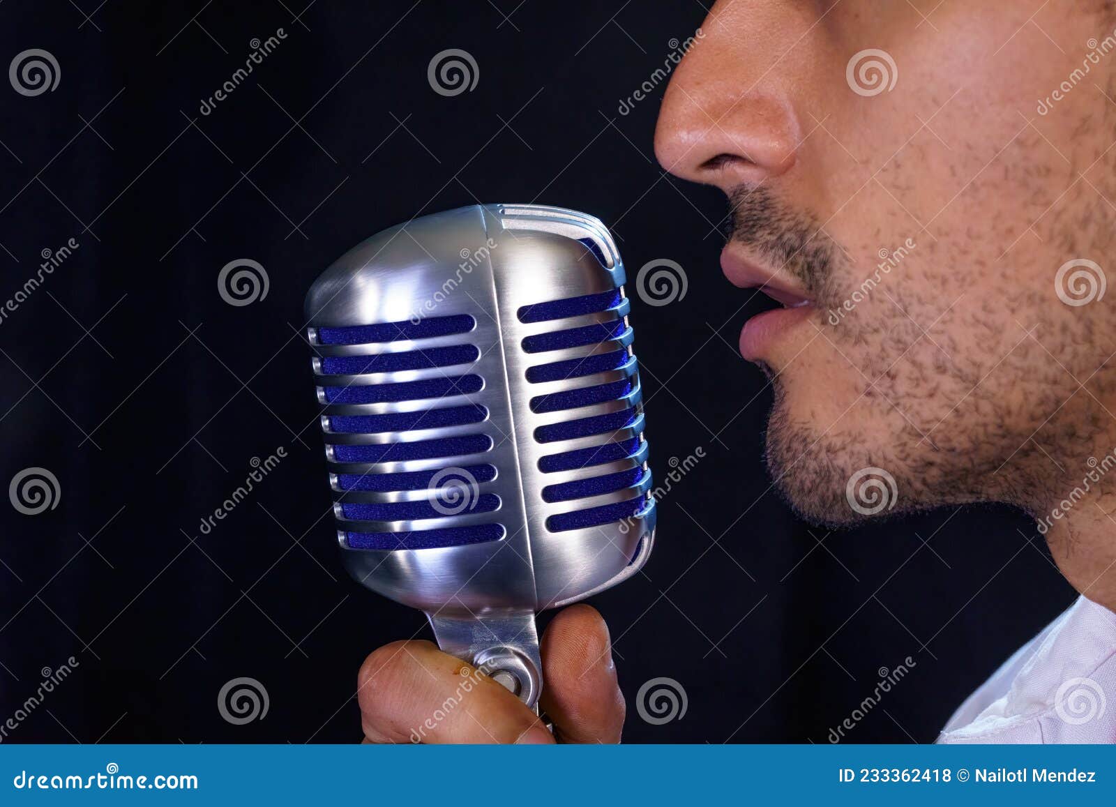 Curly-haired Mexican Pop Singer Singing with a Microphone Against a ...