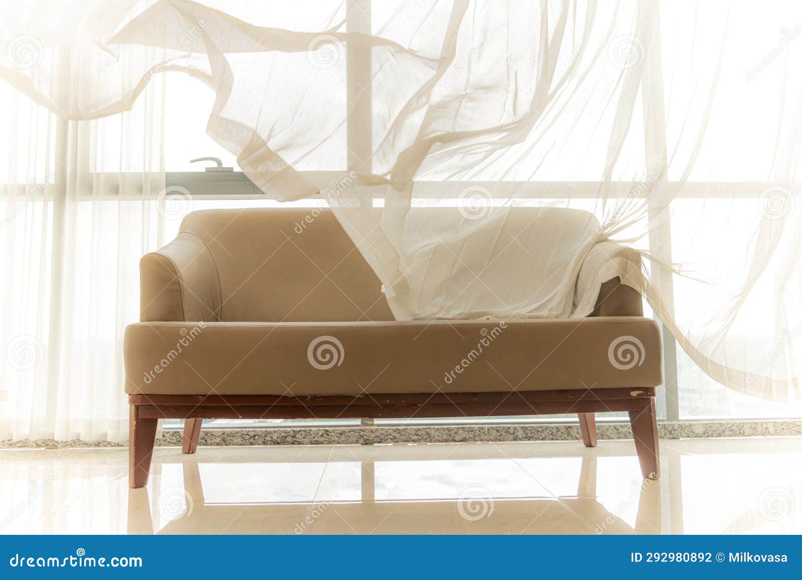 An Curtains Flutter in the Wind from an Open Window Above the Couch in ...