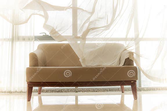 An Curtains Flutter in the Wind from an Open Window Above the Couch in ...