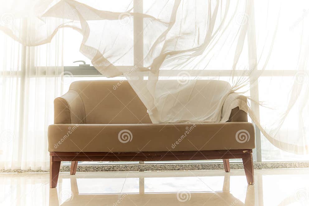 An Curtains Flutter in the Wind from an Open Window Above the Couch in ...