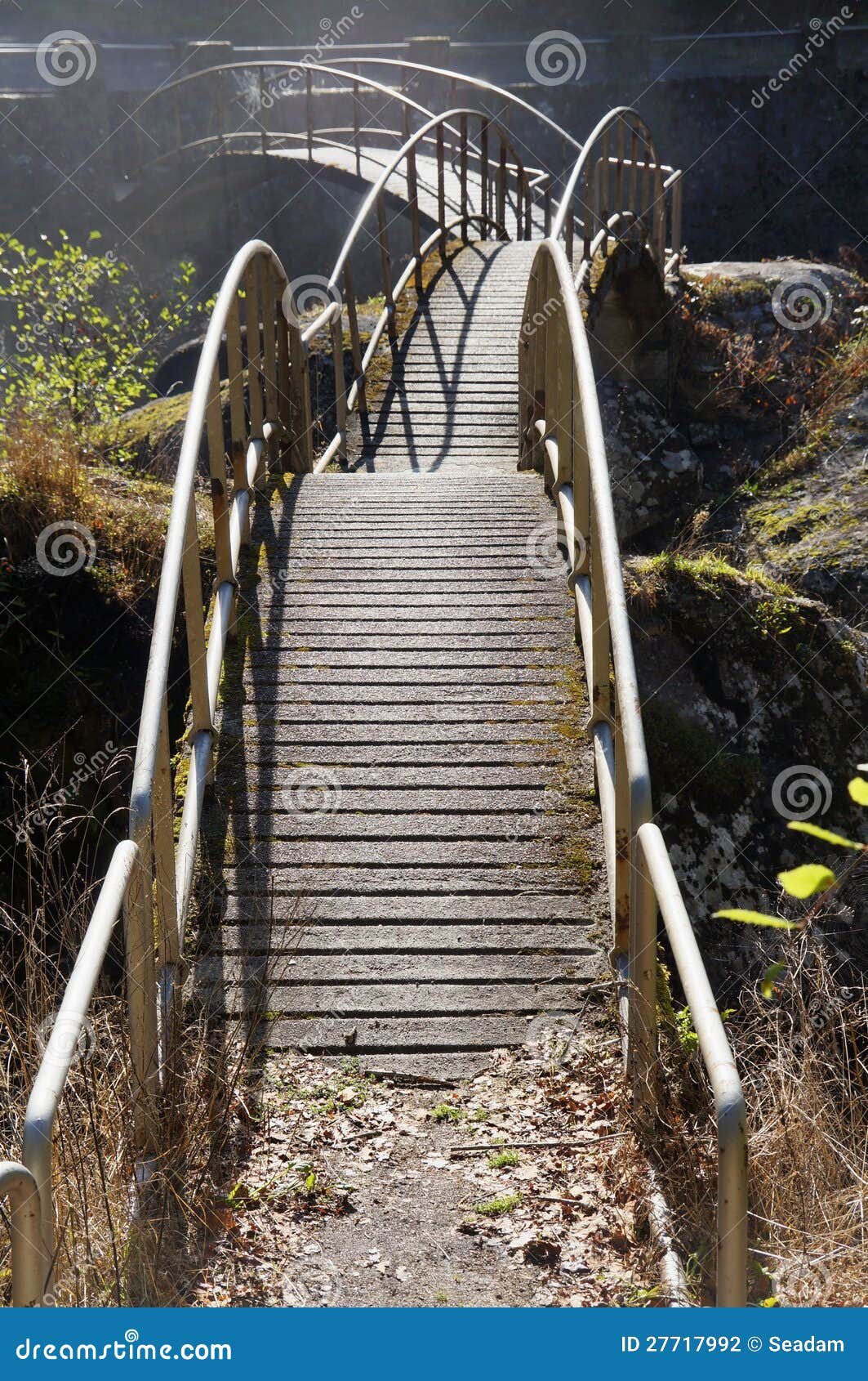 Curved Foot Bridge Over Rocks Stock Photo - Image of sunlight, path ...