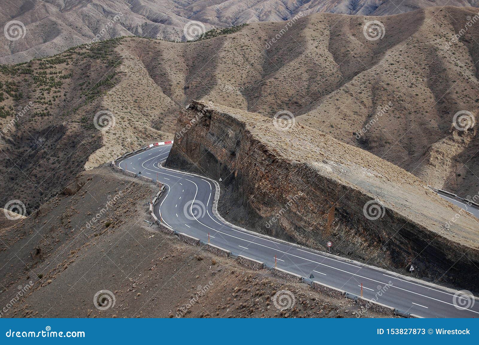 Curvy Road Around the Cliff with Mountains in the Background Stock ...