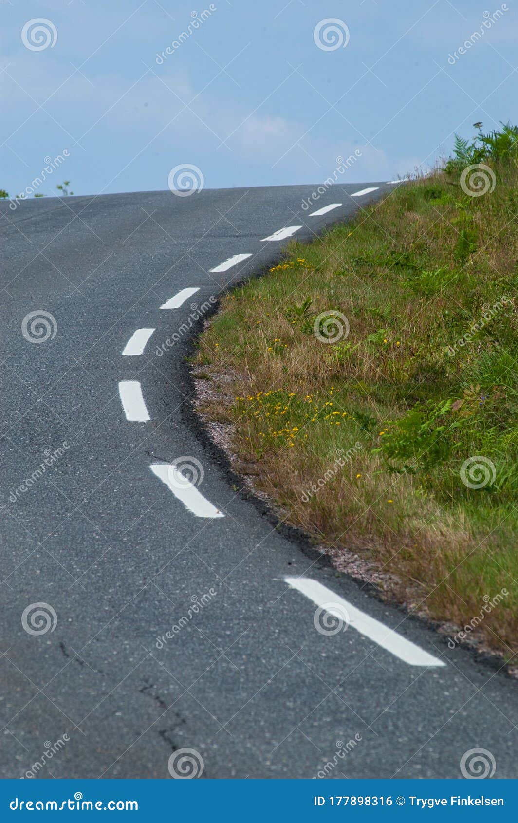 A curvy road over a crest stock photo. Image of street - 177898316