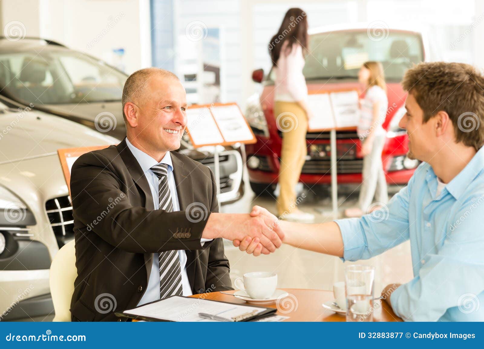 Salesman Shaking Hands With Customer While Giving Car Key In Auto ...