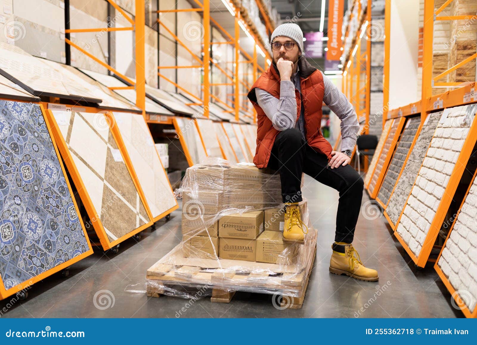 A Customer in a Hardware Store Sits on a Pallet with Ceramic Tiles ...