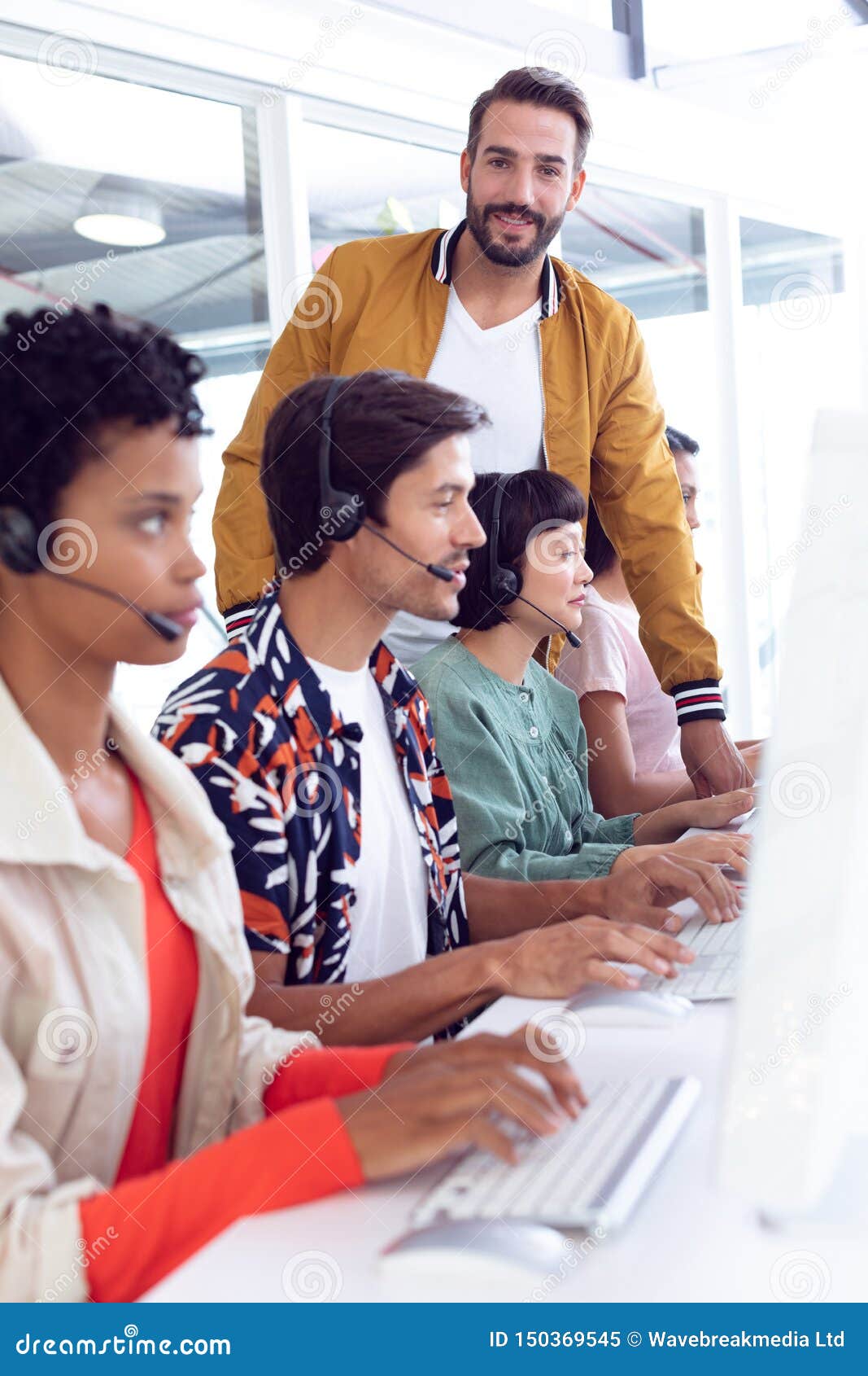 Customer Service Executive Trainer Assisting Her Team at Desk in Office ...