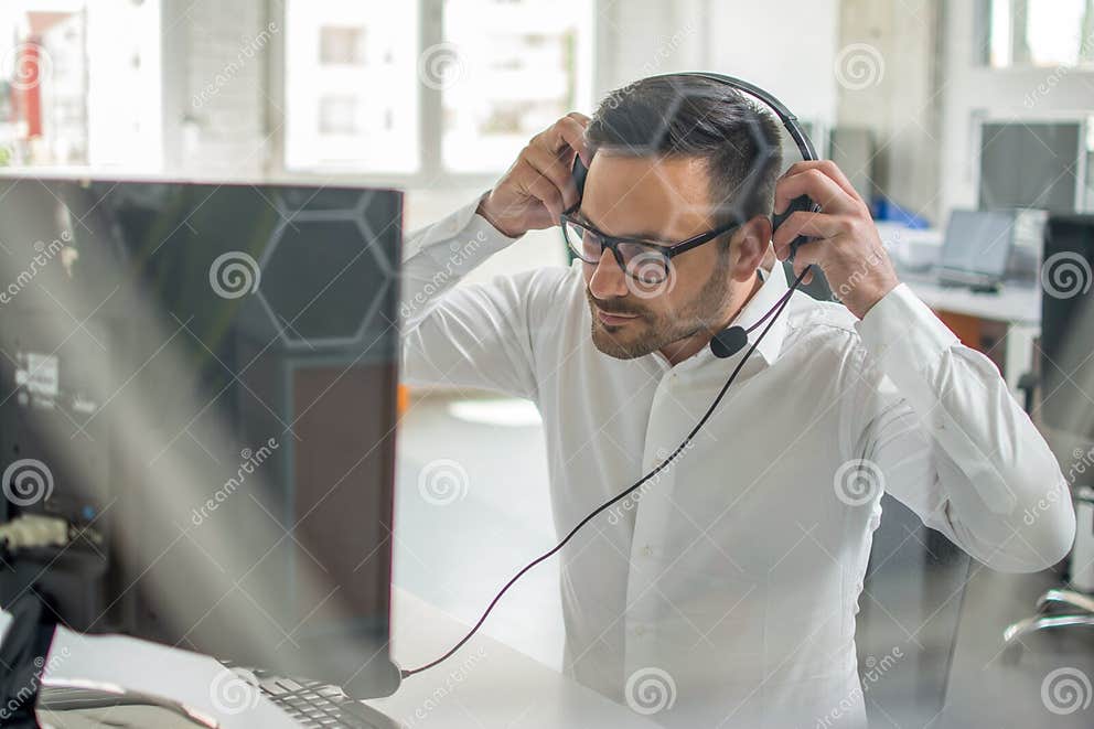 Customer Support Worker Putting on Headset with Microphone in Call ...