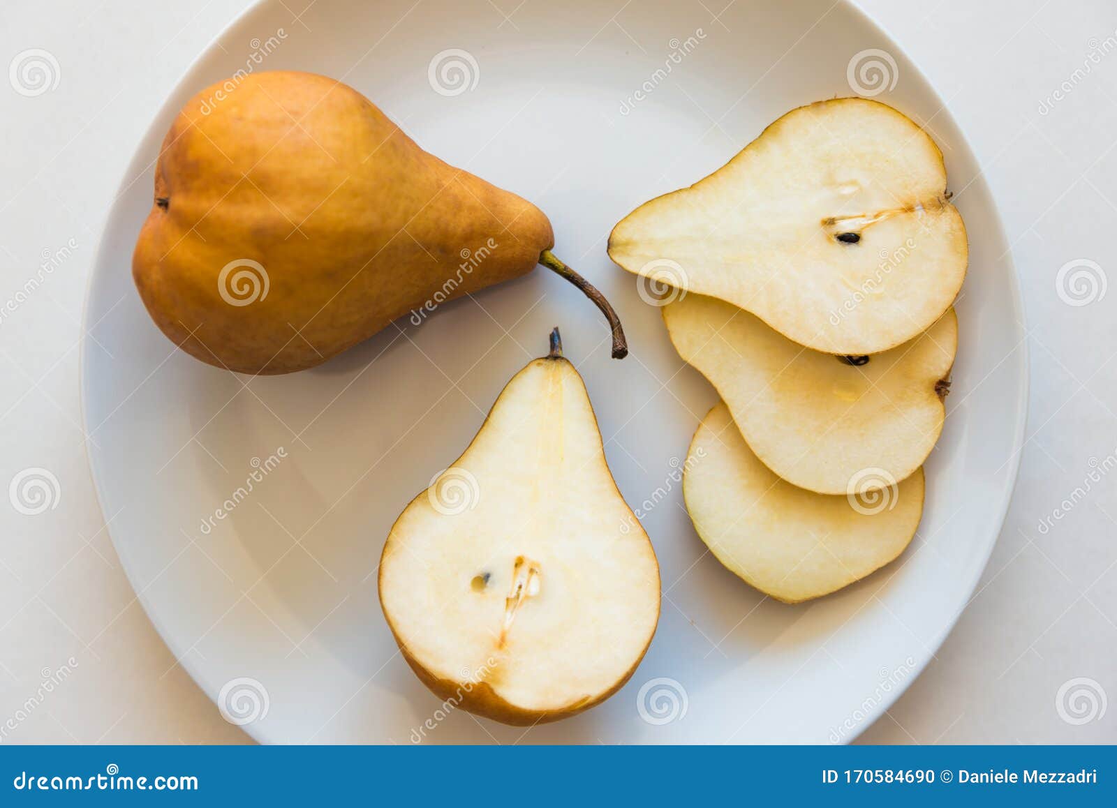Cut pears on a white plate stock photo. Image of vegan - 170584690