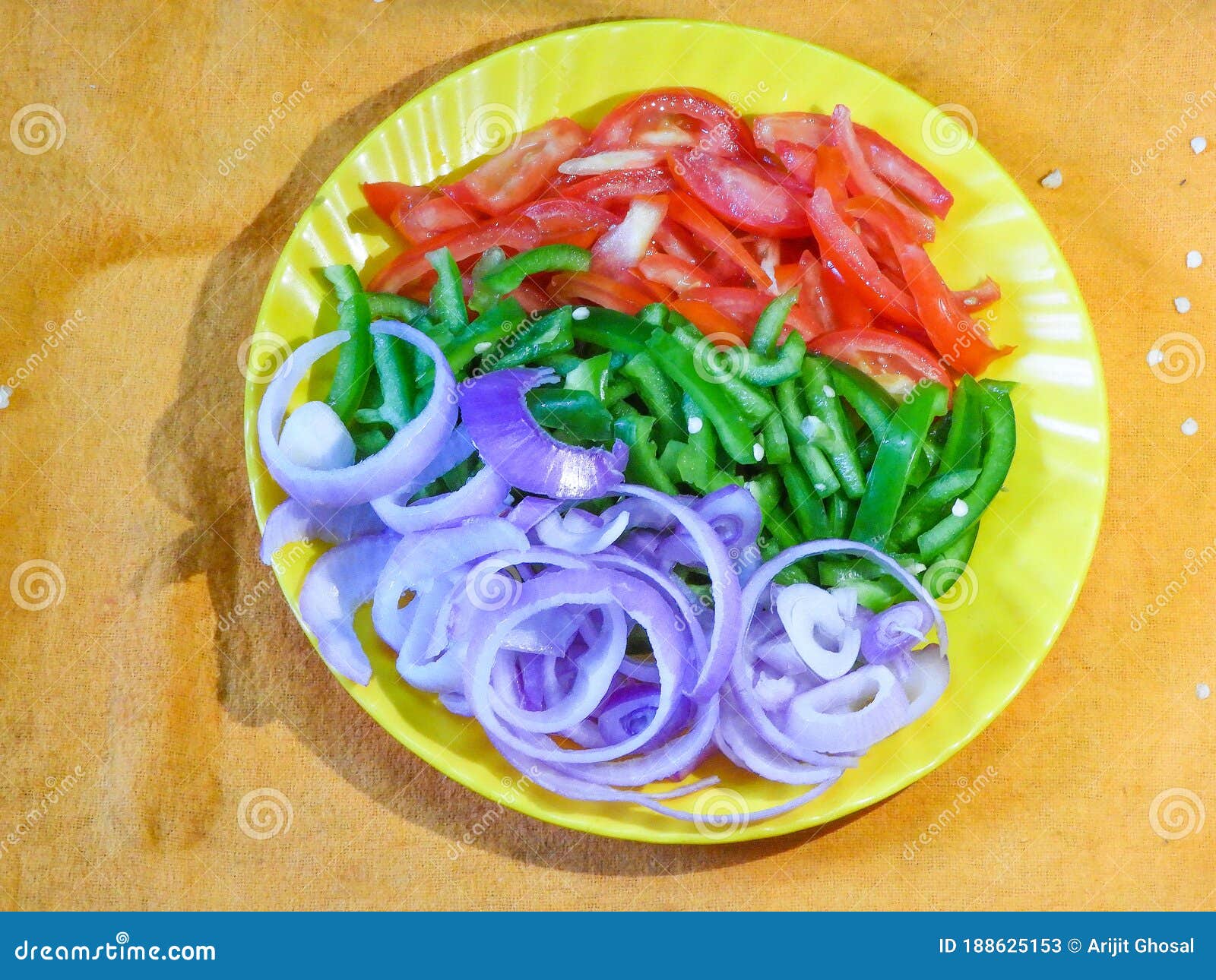 Cut Pieces of Tomato, Capcicum and Onion on a Same Yellow Plate Stock ...