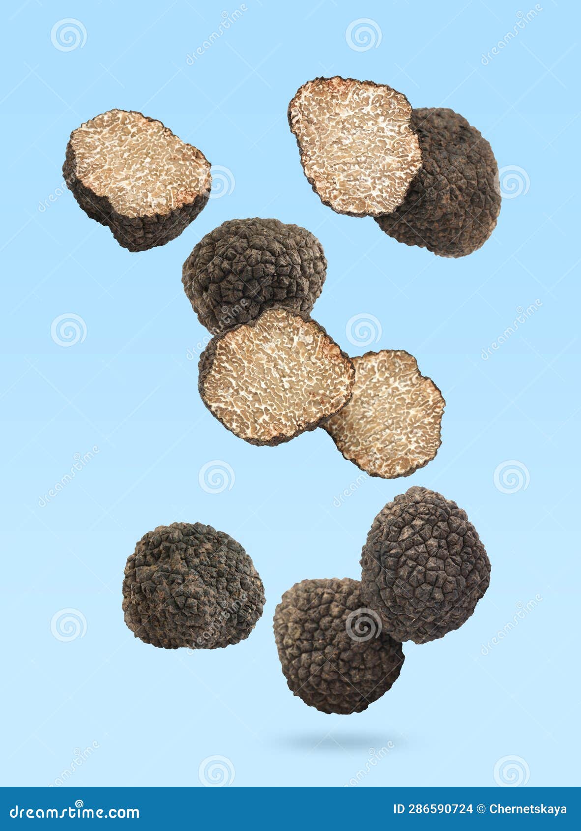 Cut and Whole Truffles Falling on Light Blue Background Stock Photo ...