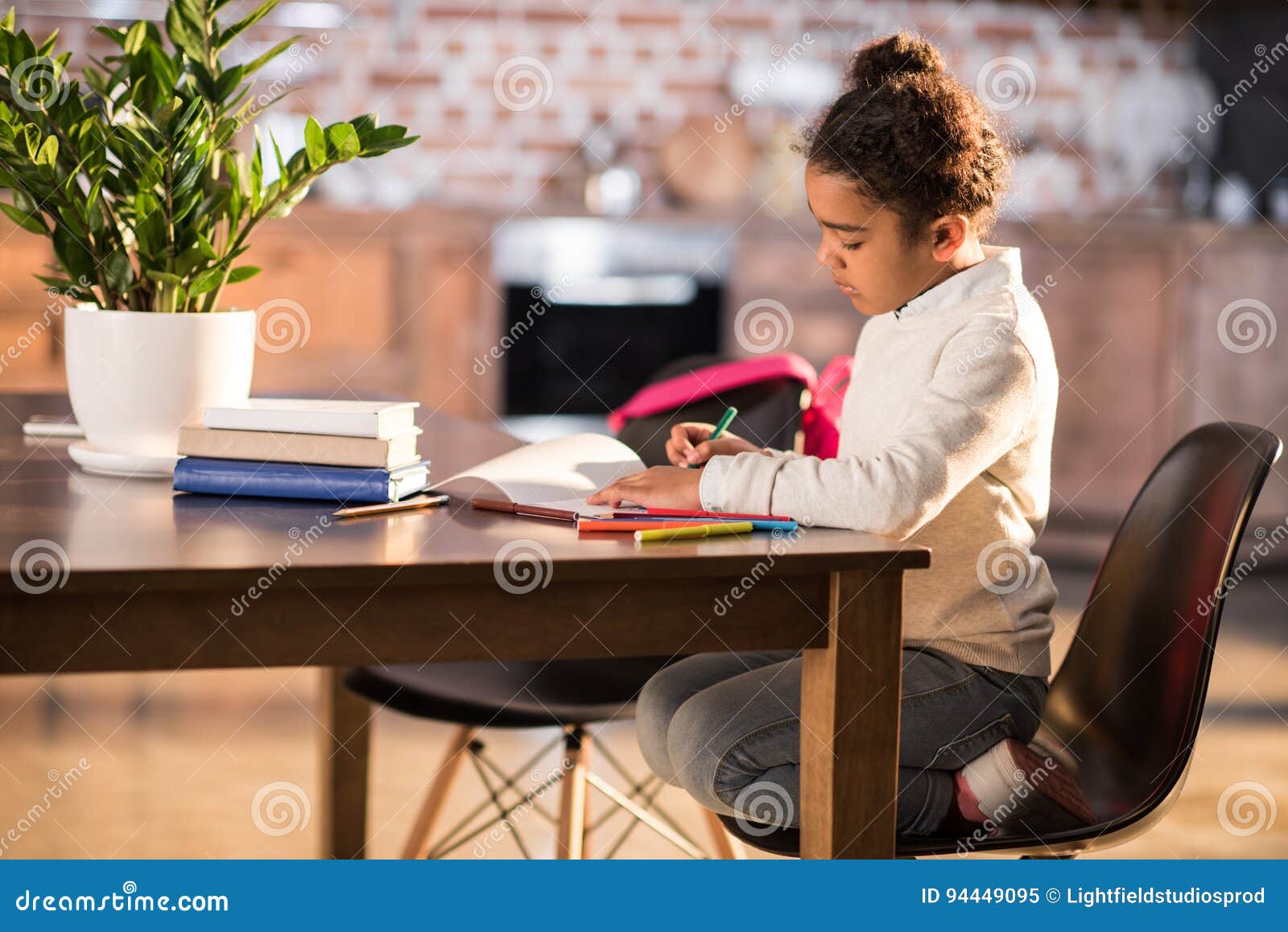 Cute African American Girl Sitting at Table and Doing Homework Stock ...