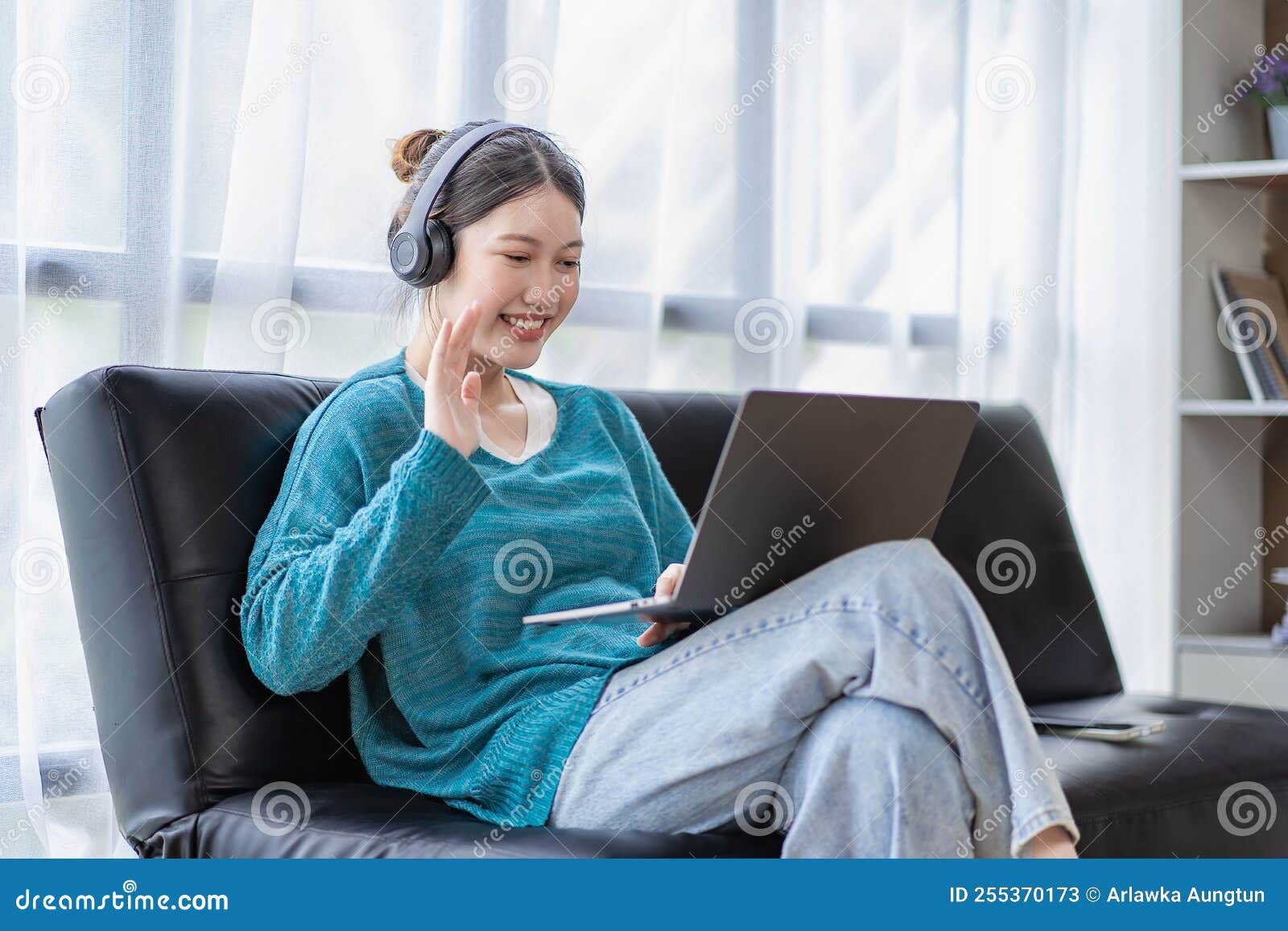 Cute Asian Woman Smiling Using a Headset Looking at a Laptop Computer ...