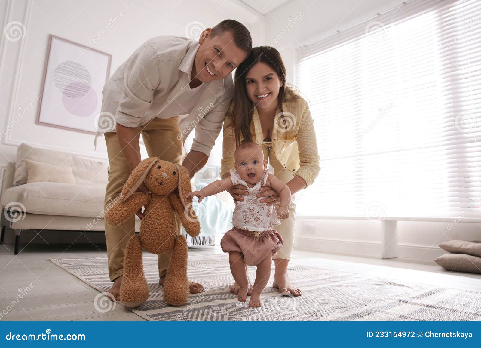 Cute Little Baby Doing First Steps with Parents` Help at Home Stock ...
