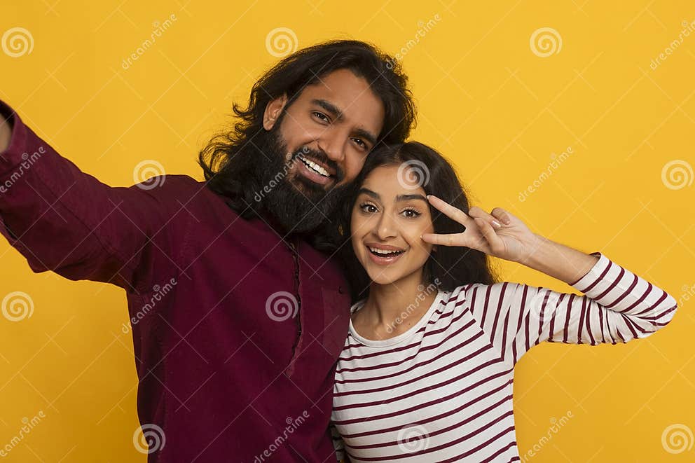 Cute Beautiful Young Indian Couple Take Selfie On Yellow Stock Image