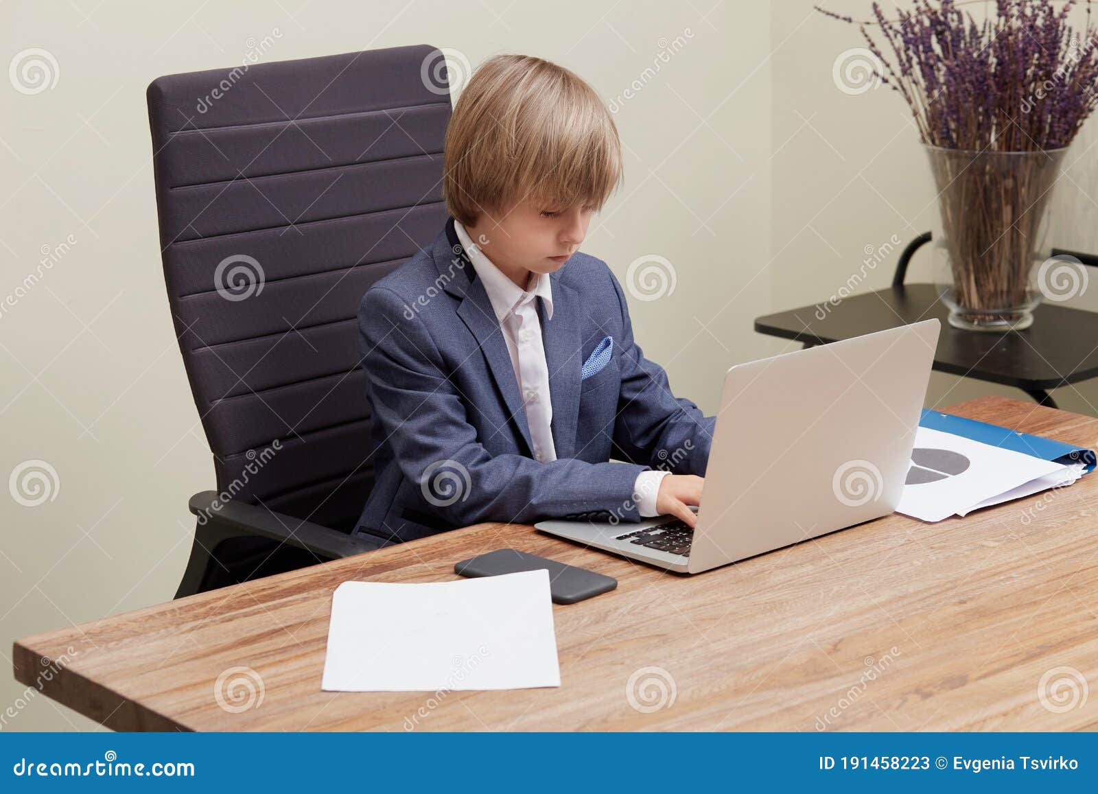 Cute Blond Boy Concentratedly Works in the Office Behind a Laptop ...
