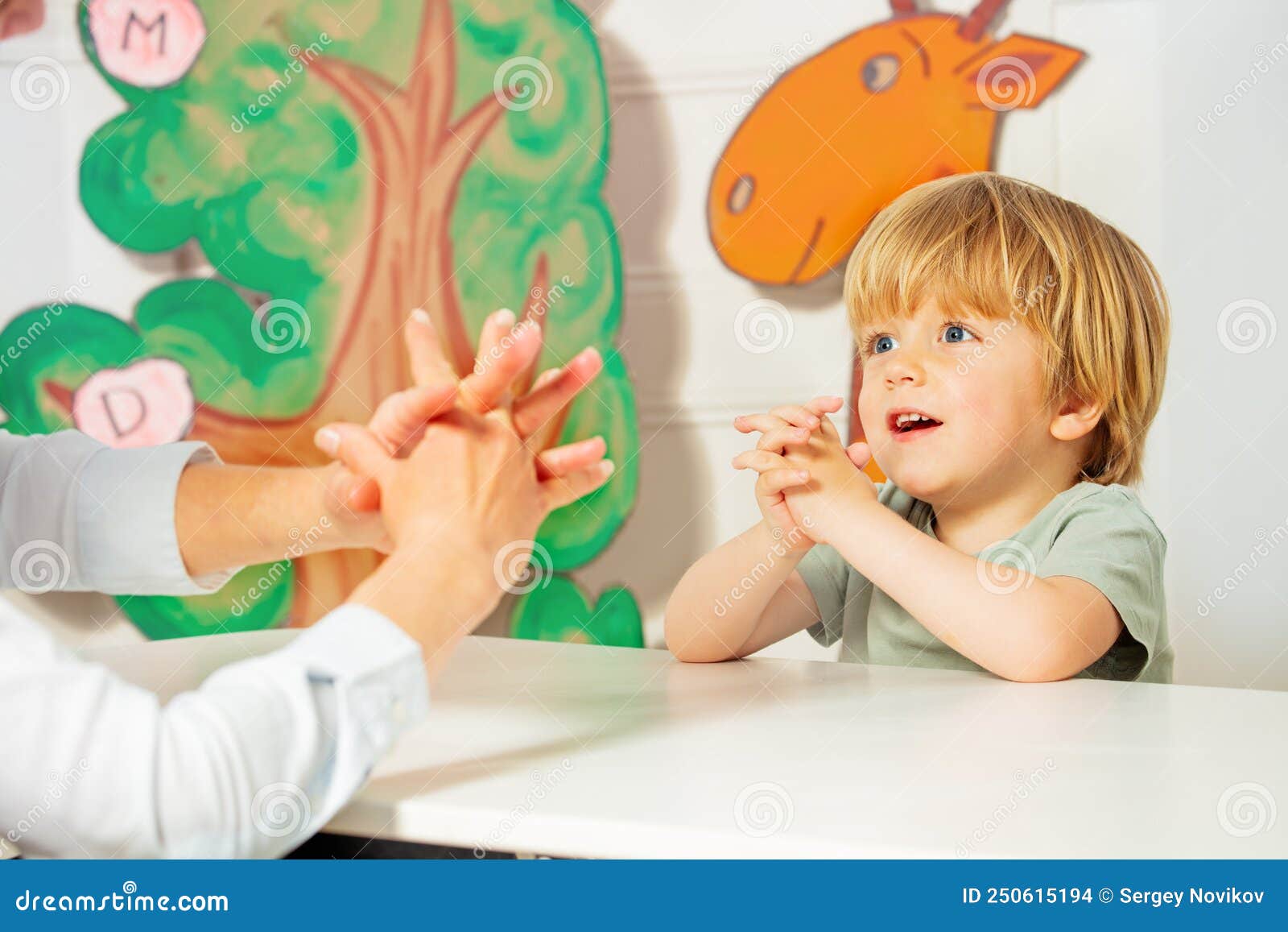 Cute Blond Boy Play Finger Game Sitting by the Desk in Class Stock ...