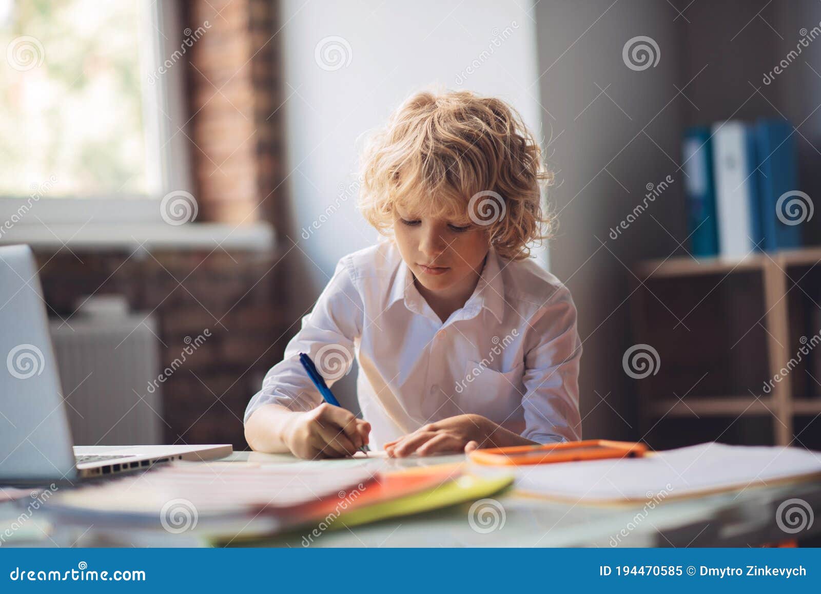 Cute Blonde Boy Sitting at the Table and Writing Stock Image - Image of ...