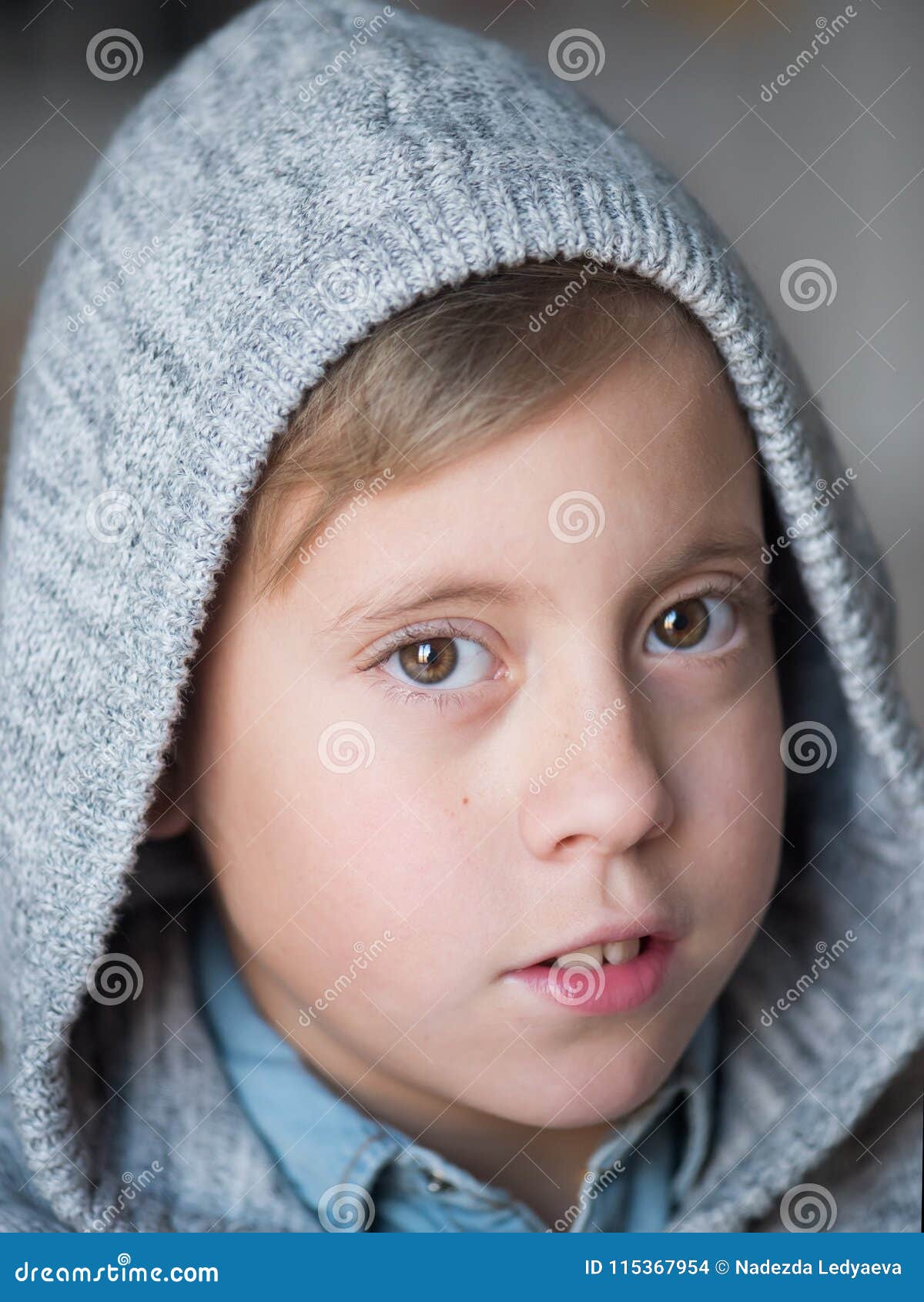 Cute Blonde in a Hood Looking at the Camera Stock Photo - Image of ...