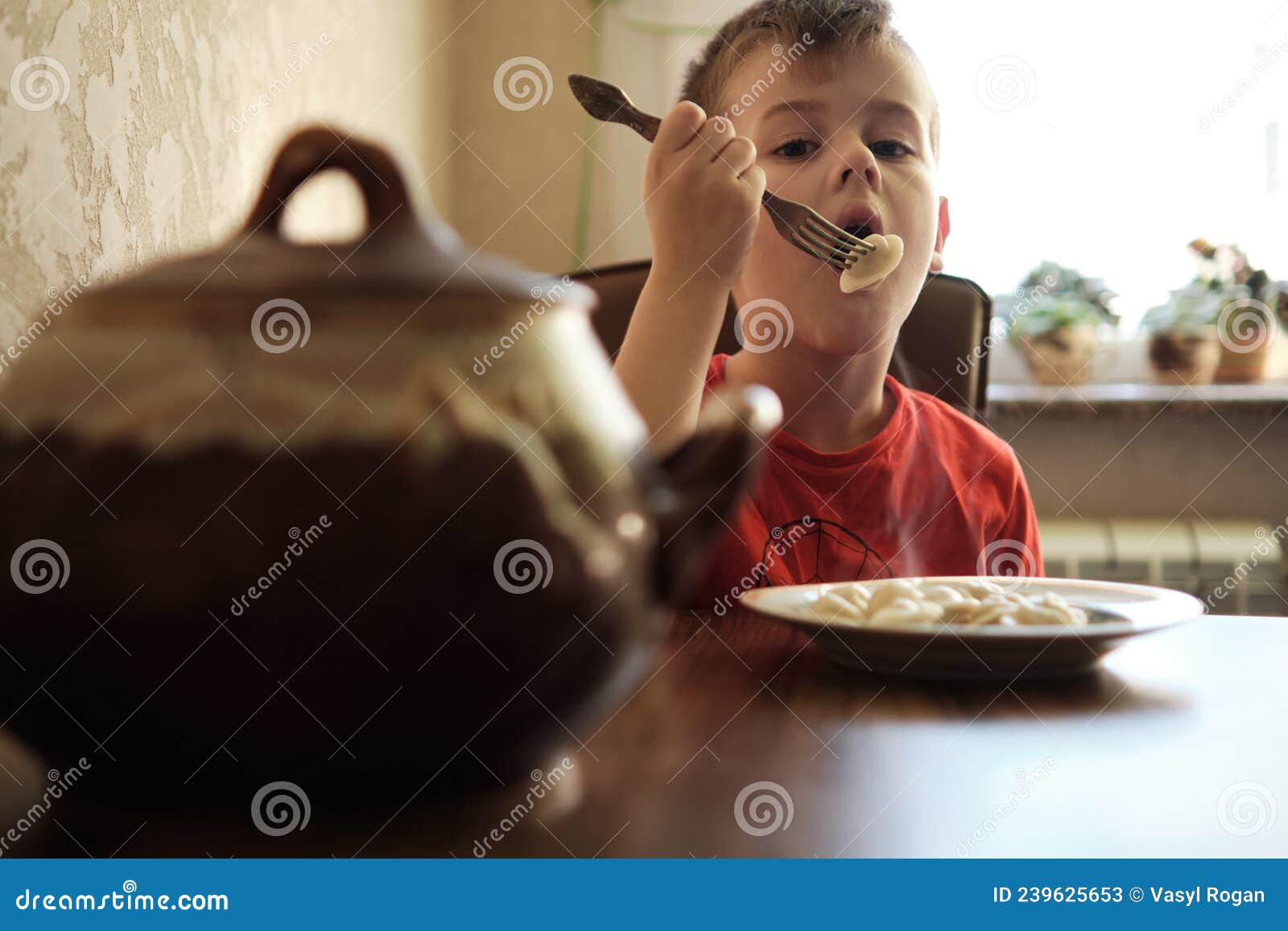 Cute Boy Eating Dumplings on the Table in the Kitchen Stock Image ...