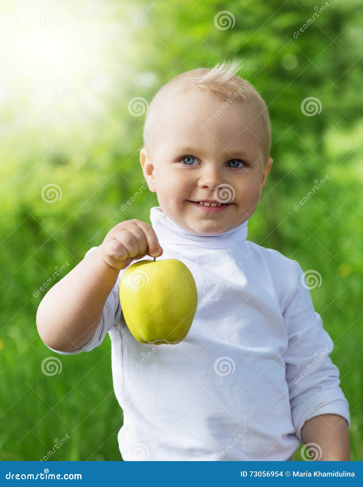 Cute boy holding an apple stock photo. Image of garden - 73056954