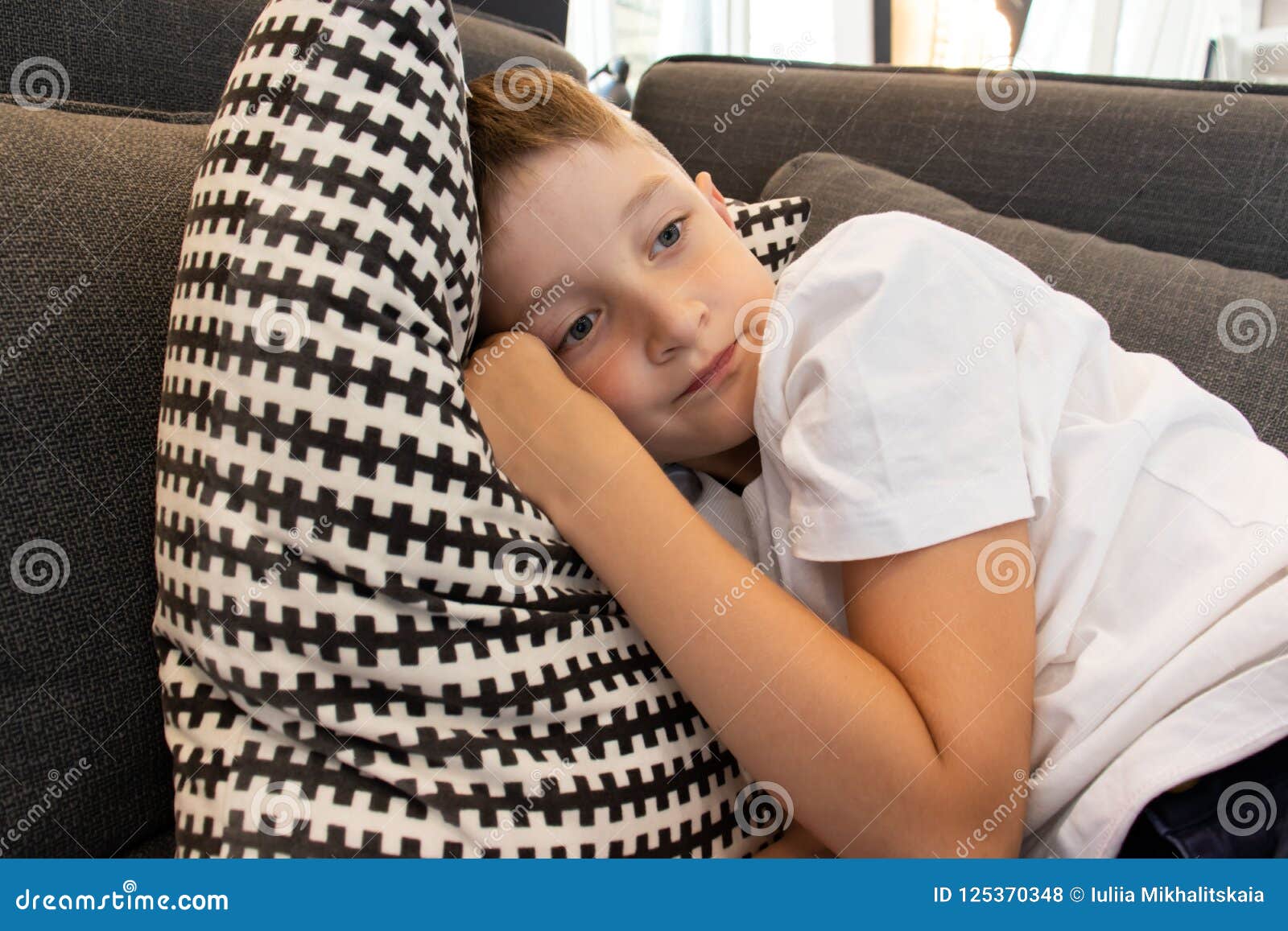 A Cute Boy Lying on a Sofa and Put a Head on Black and White Checkered ...