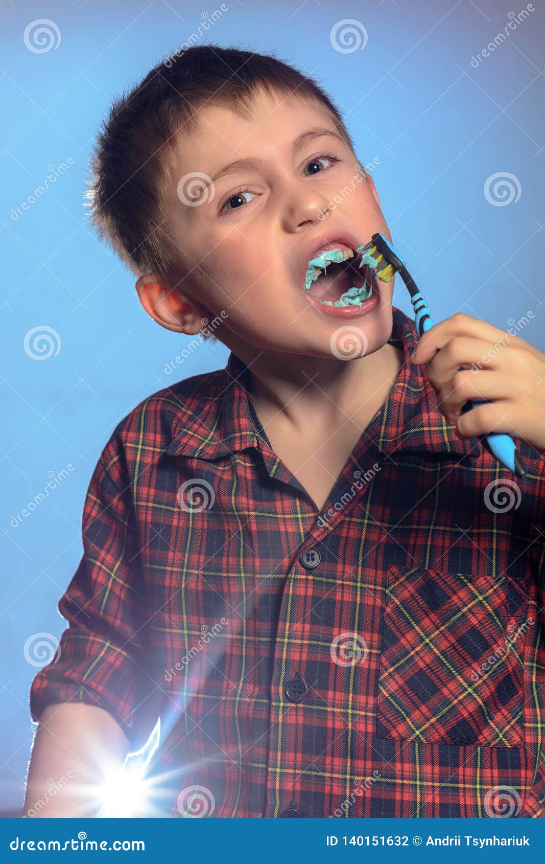 A Cute Boy in a Pajamas Brushes Teeth with Toothpaste before Bedtime on ...