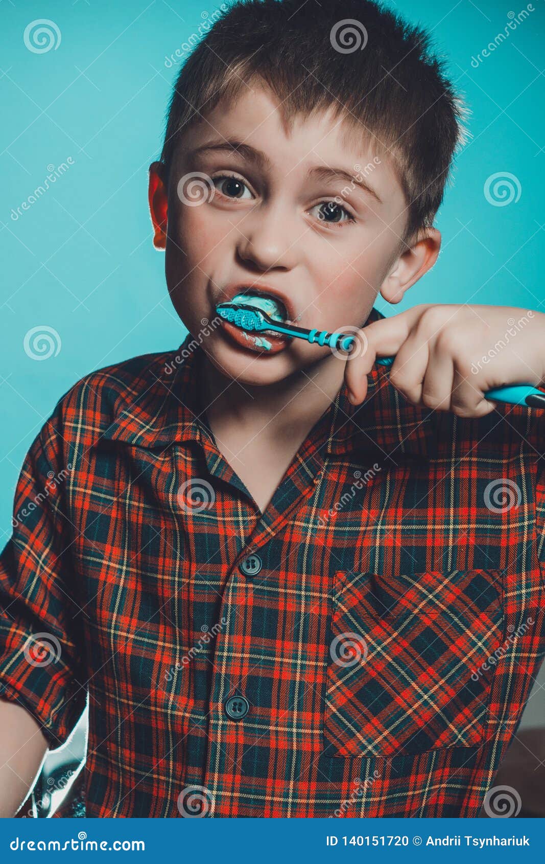 A Cute Boy in a Pajamas Brushes Teeth with Toothpaste before Bedtime on ...