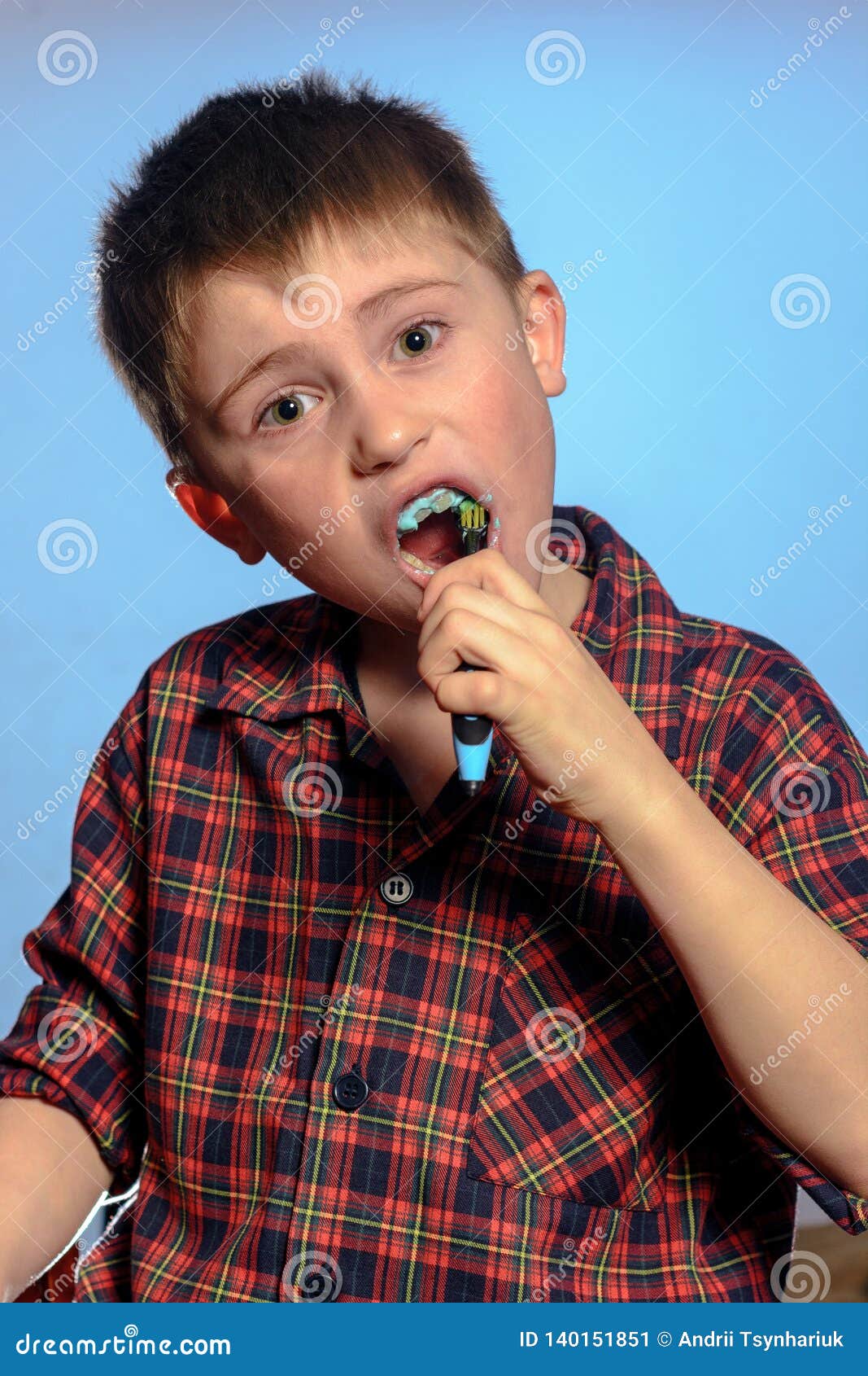 A Cute Boy in a Pajamas Brushes Teeth with Toothpaste before Bedtime on ...