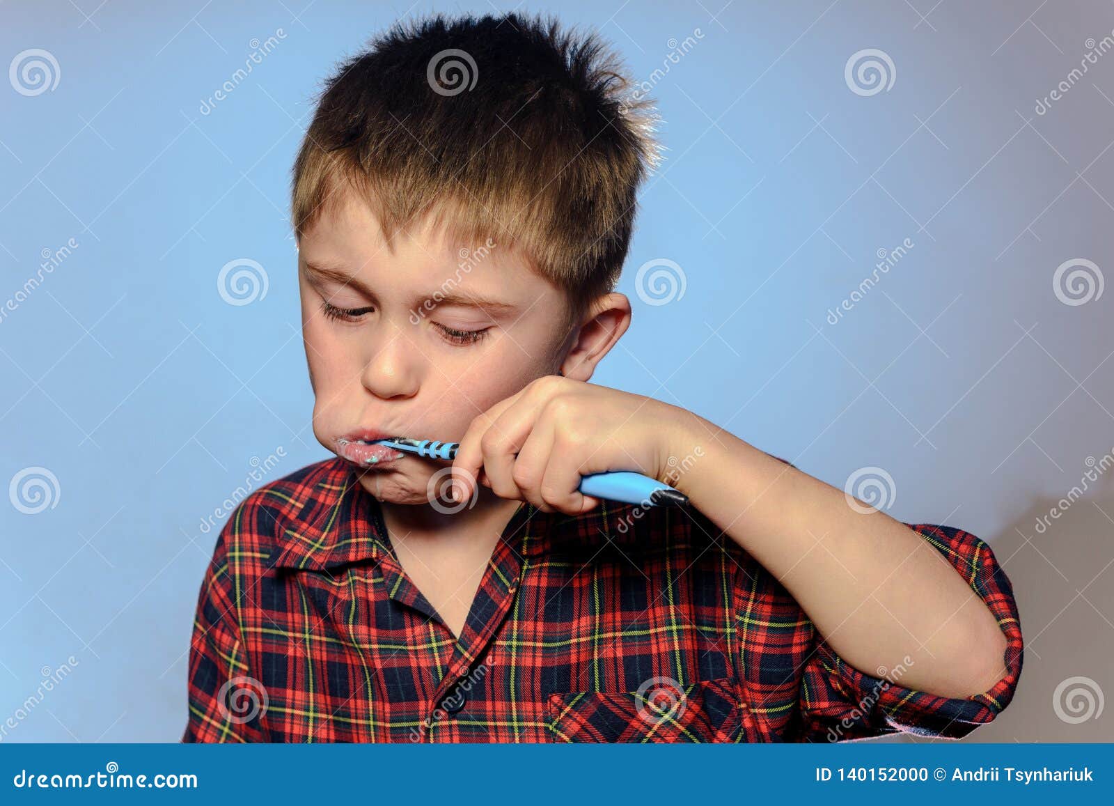A Cute Boy in a Pajamas Brushes Teeth with Toothpaste before Bedtime on ...
