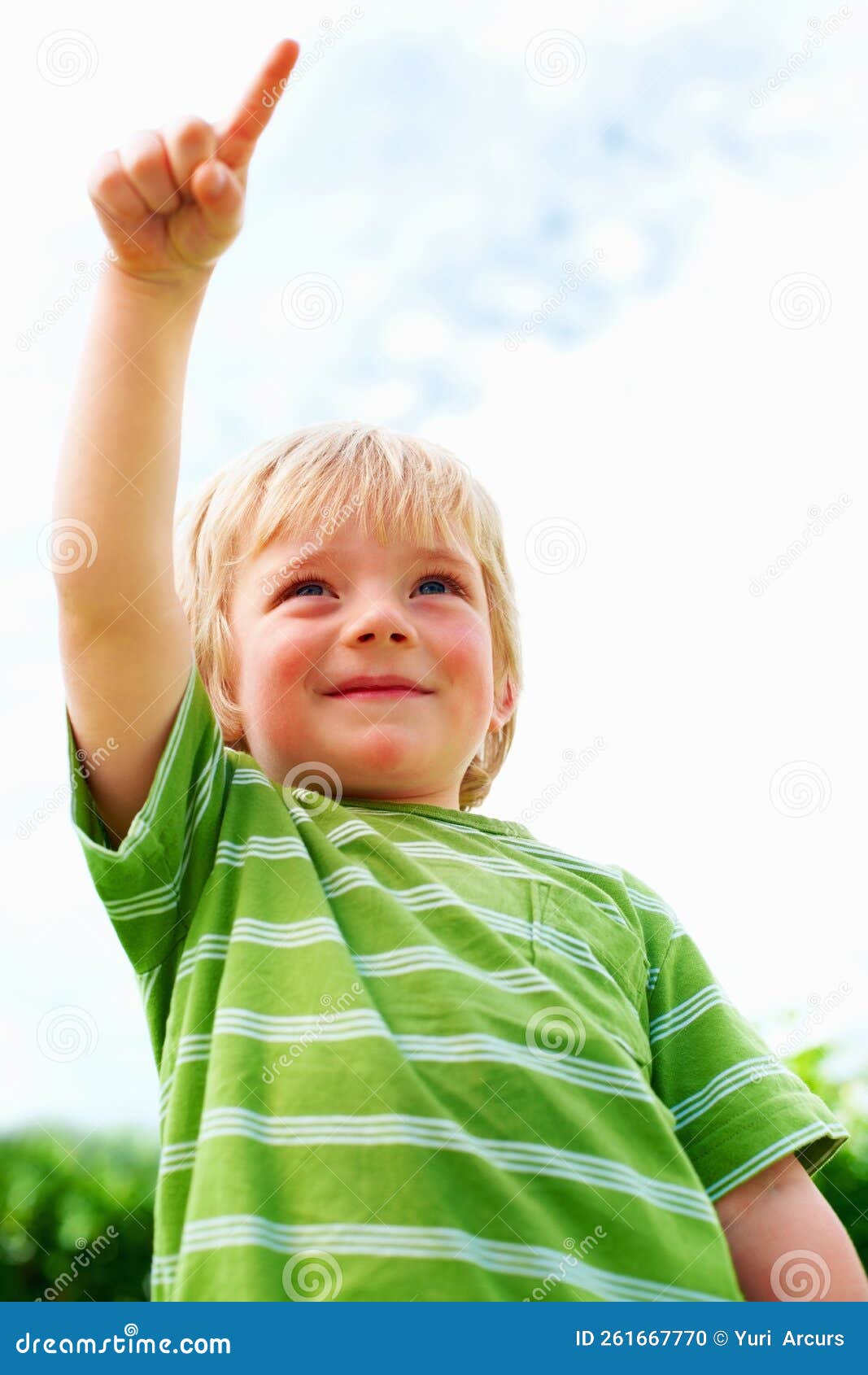 Cute Boy Pointing at Something. Low Angle View of Cute Boy Smiling and ...