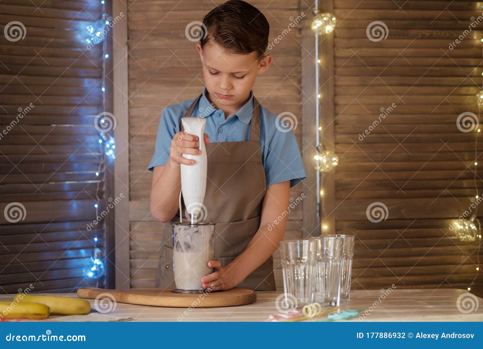 A Cute Boy Prepares a Milkshake with a Banana. Stock Photo - Image of ...