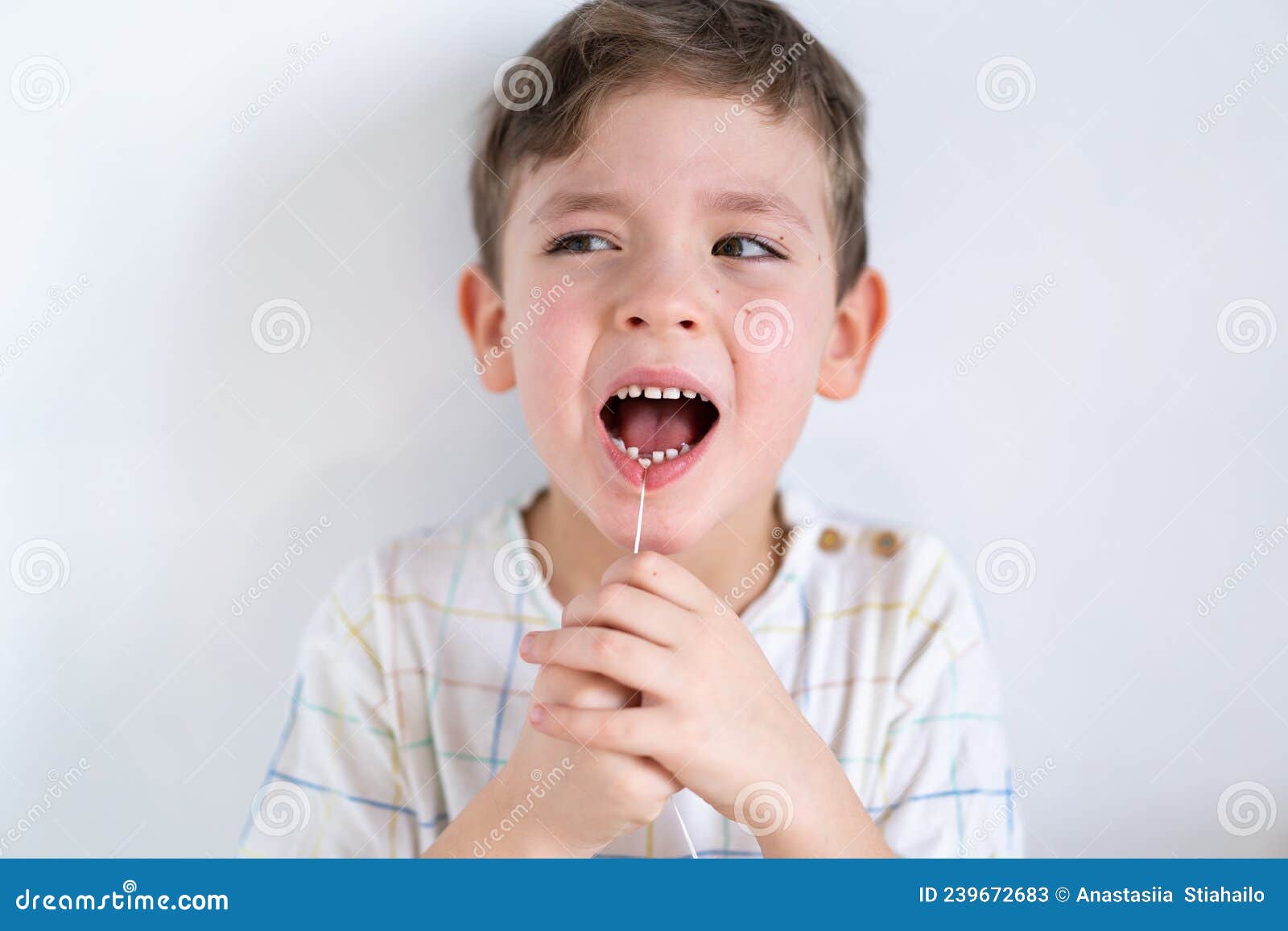 Cute Boy Pulling Loose Tooth Using a Dental Floss. Process of Removing ...