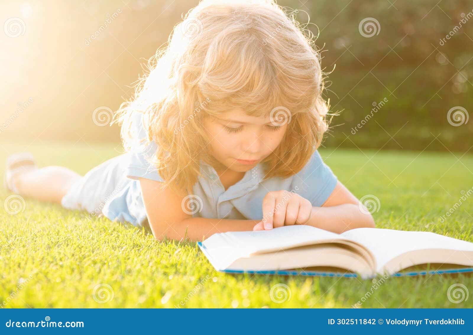 Cute Boy Reading Book on Green Grass. Stock Photo - Image of grass ...