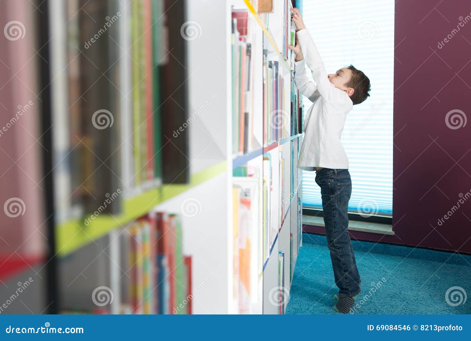 Cute Boy Reading Book in Library Stock Photo - Image of child ...