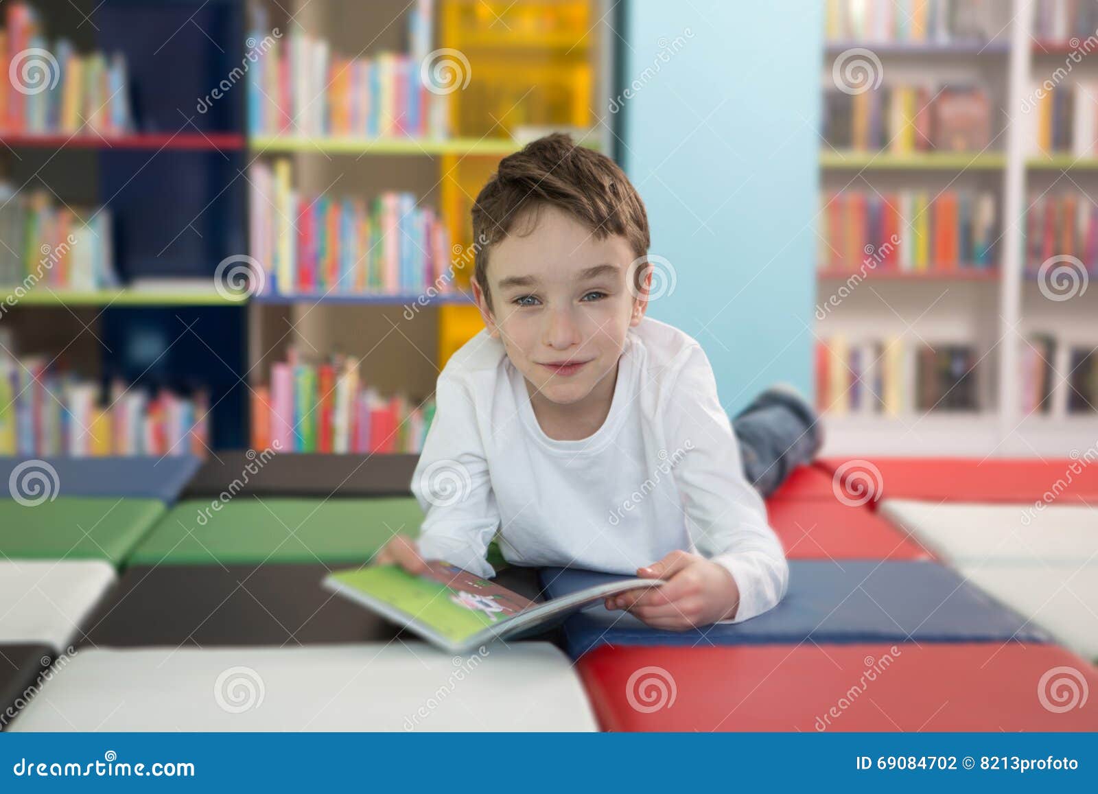 Cute Boy Reading Book in Library Stock Photo - Image of child ...