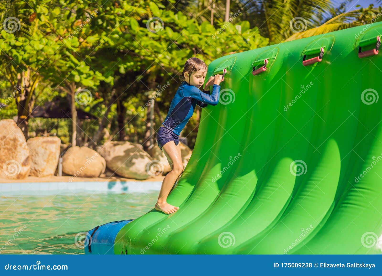 Cute Boy Runs an Inflatable Obstacle Course in the Pool Stock Photo ...