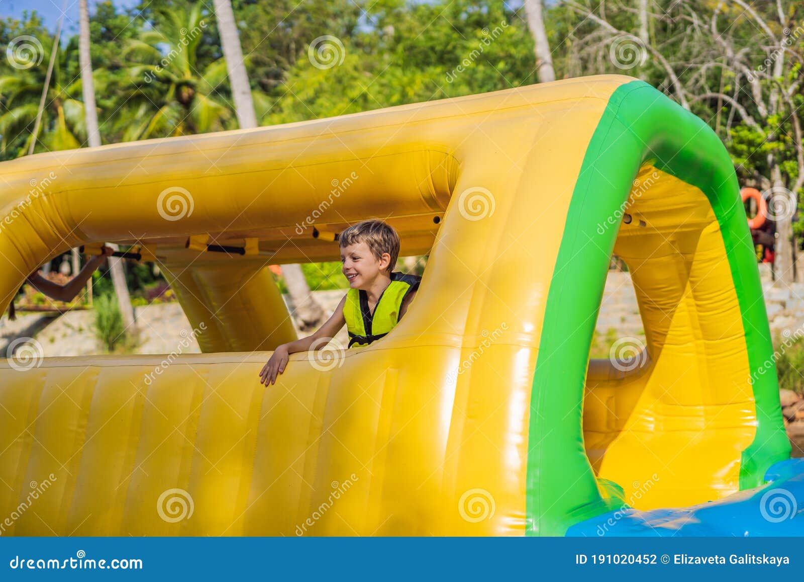 Cute Boy Runs an Inflatable Obstacle Course in the Pool Stock Photo ...