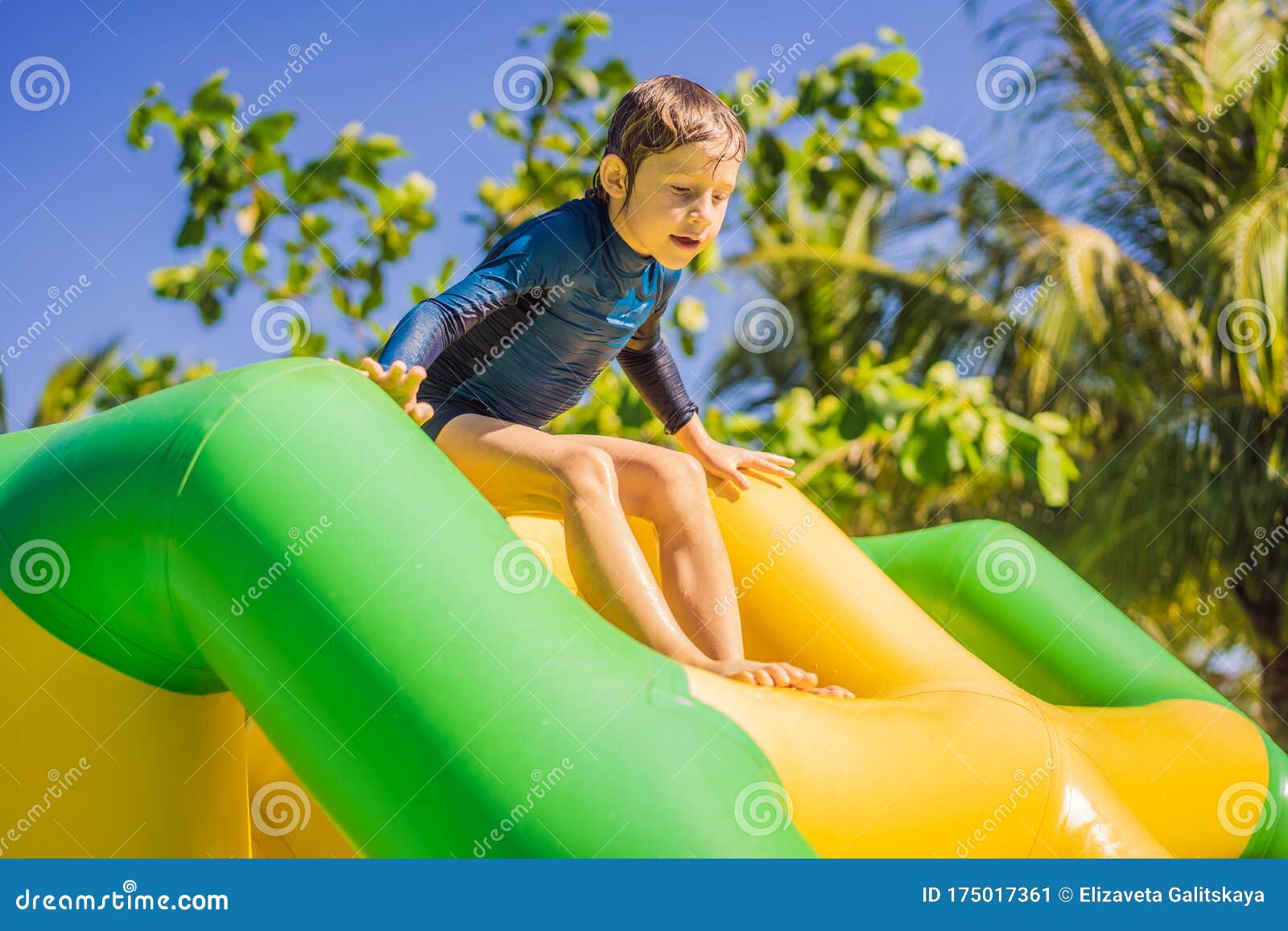 Cute Boy Runs an Inflatable Obstacle Course in the Pool Stock Image ...