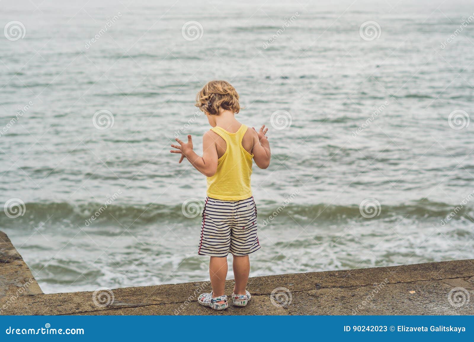 Cute Boy Stands on the Shore Watching the Ocean Waves Stock Image ...