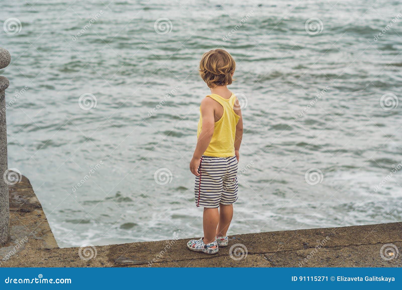 Cute Boy Stands on the Shore Watching the Ocean Waves Stock Image ...