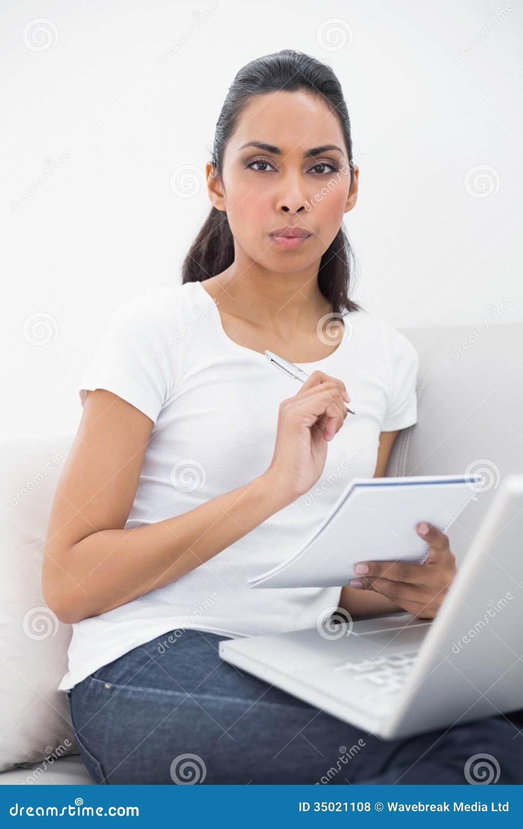 Cute Casual Woman Holding a Notebook while Using Her Laptop Stock Photo ...