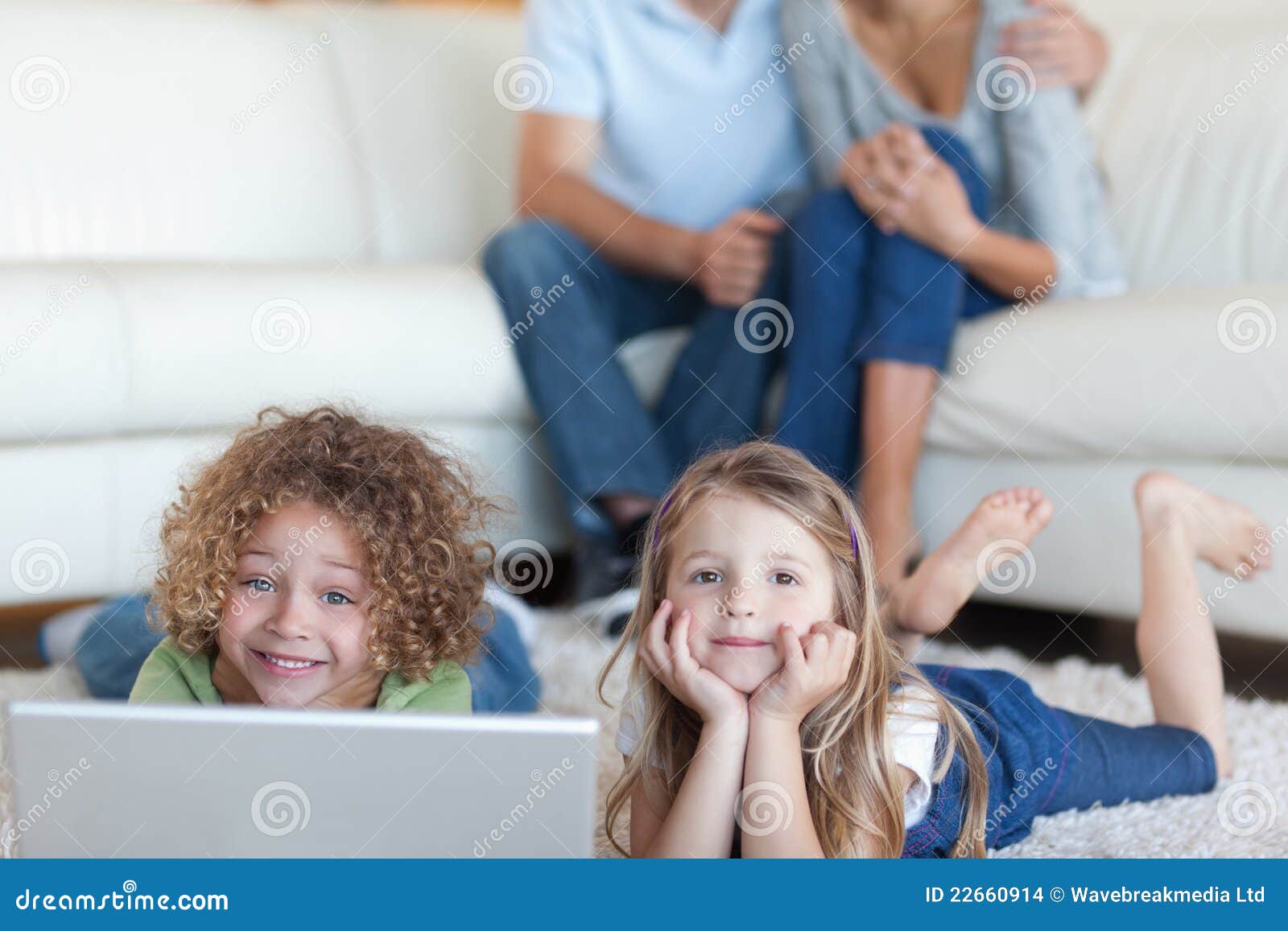 Cute Children Using a Laptop while Their Parents are Watching Stock ...
