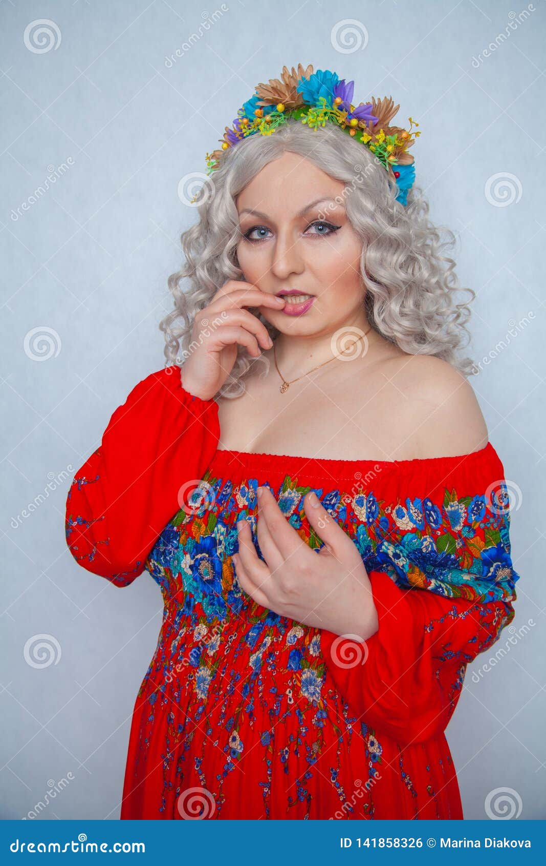 Cute Chubby Girl With Flowers In White Curly Hair In Red Rustic Dress
