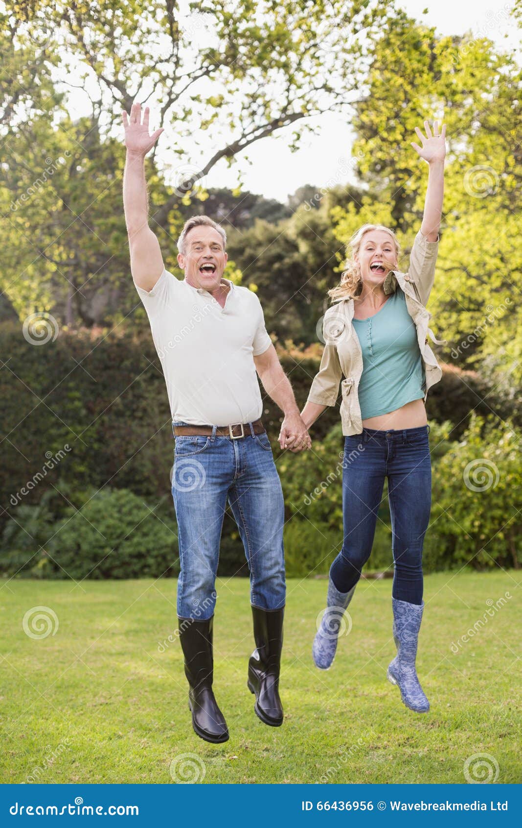 Cute Couple Jumping with Arms in the Air Stock Photo - Image of garden ...