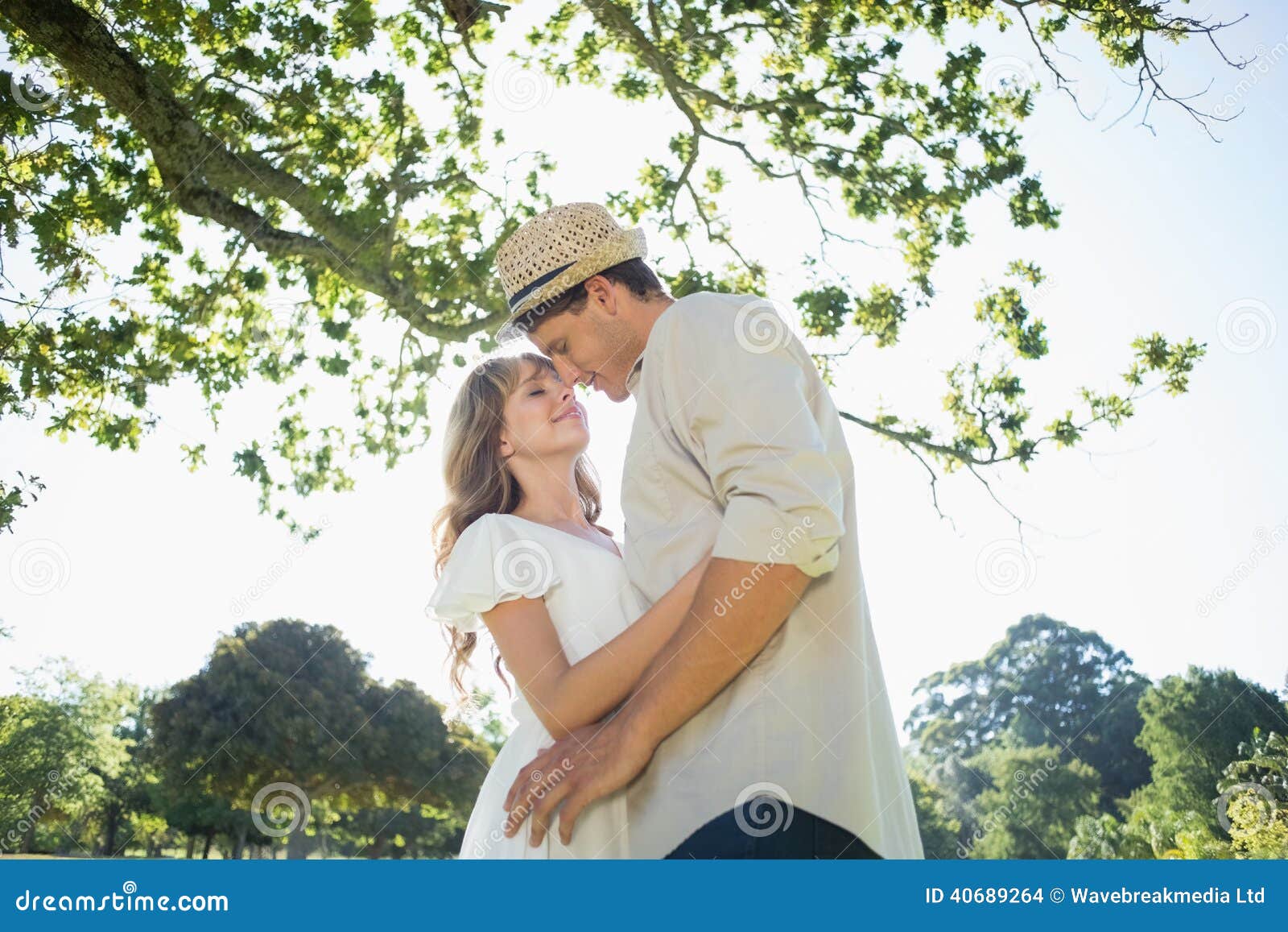 Cute Couple Standing in the Park Embracing Stock Photo - Image of ...
