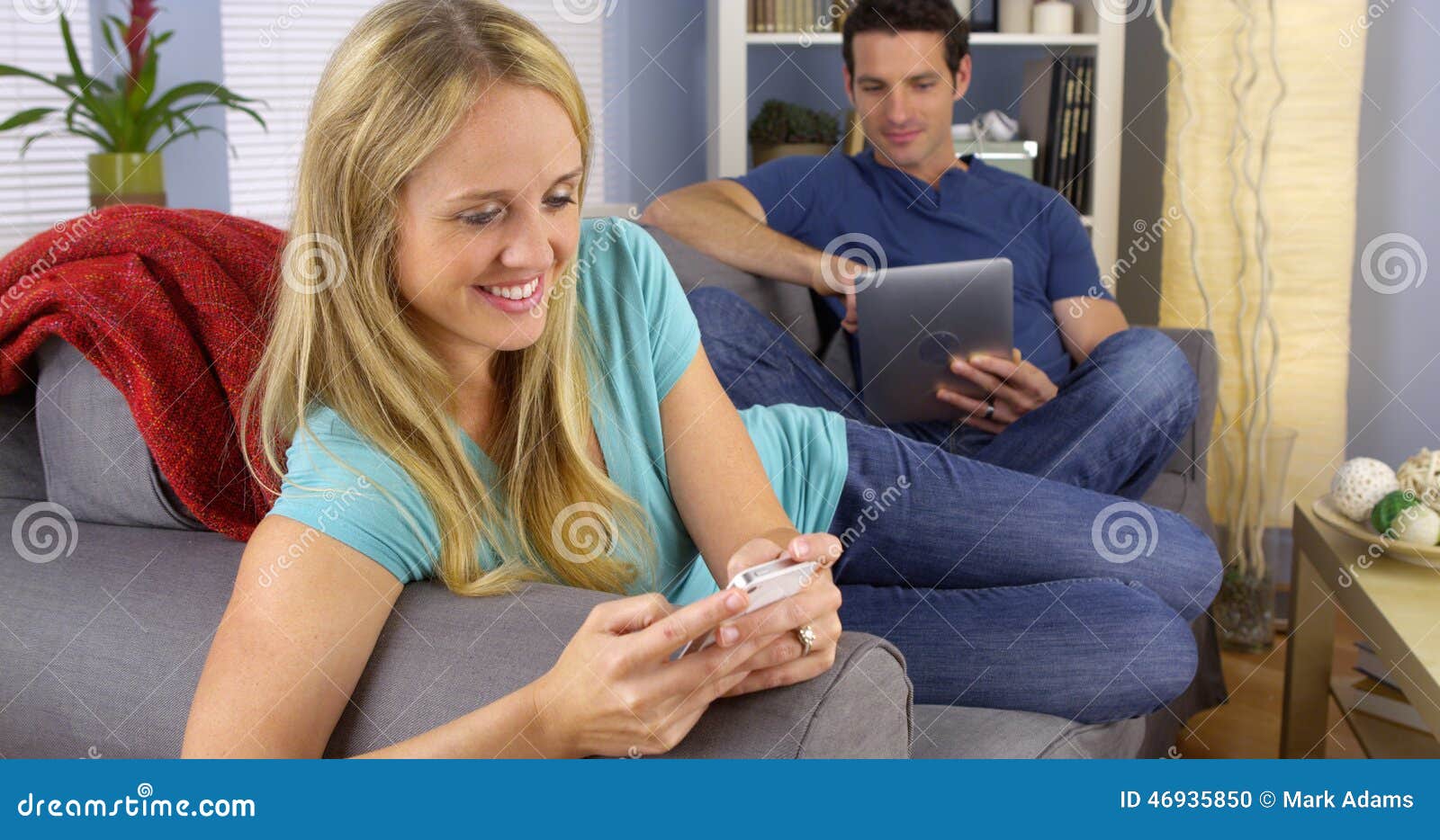 Cute Couple Using Their Gadgets on Couch Stock Photo - Image of indoors ...