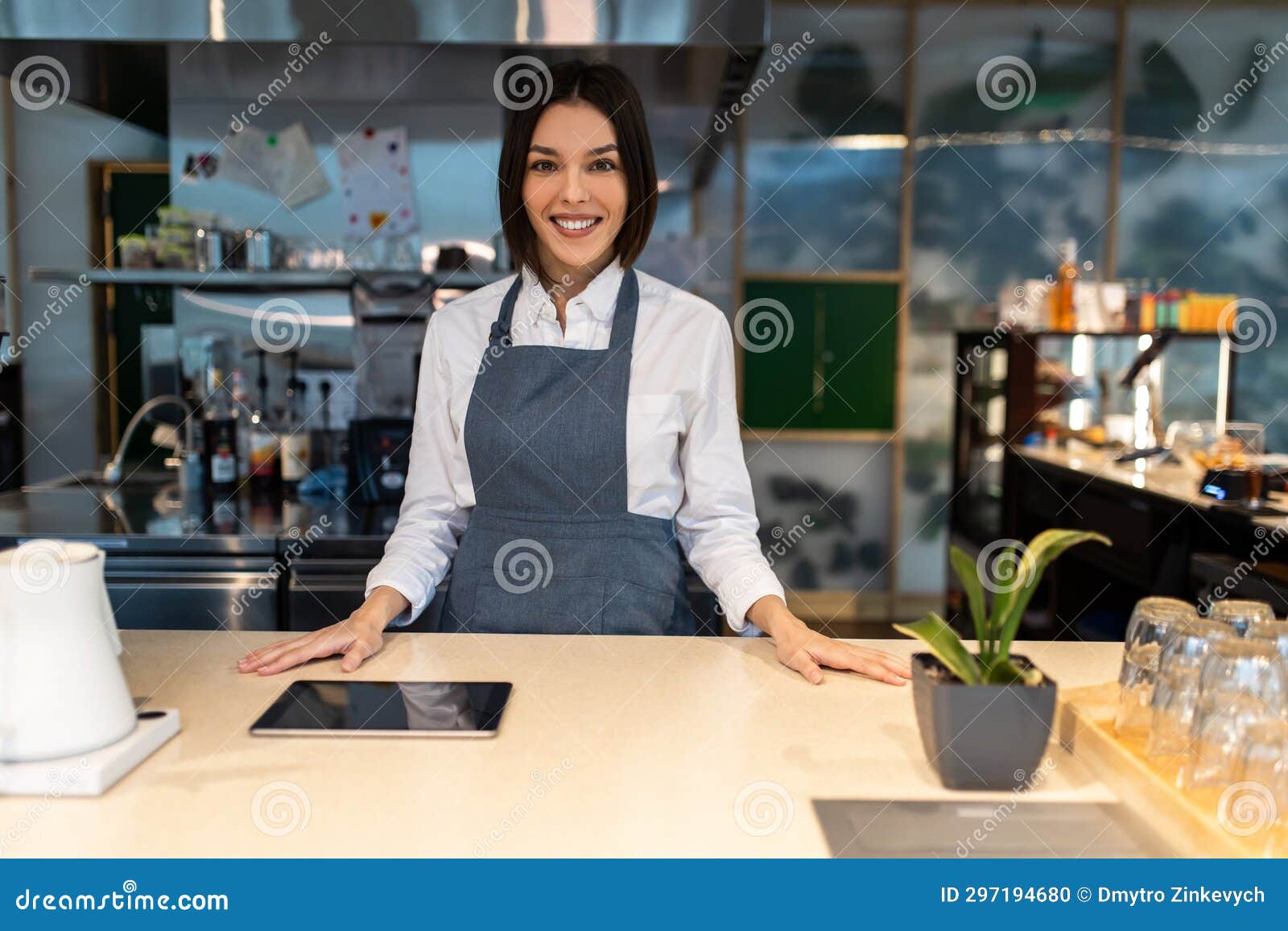 Cute Dark-haired Coffee Shop Assistant with a Tablet in Hand Smiling ...