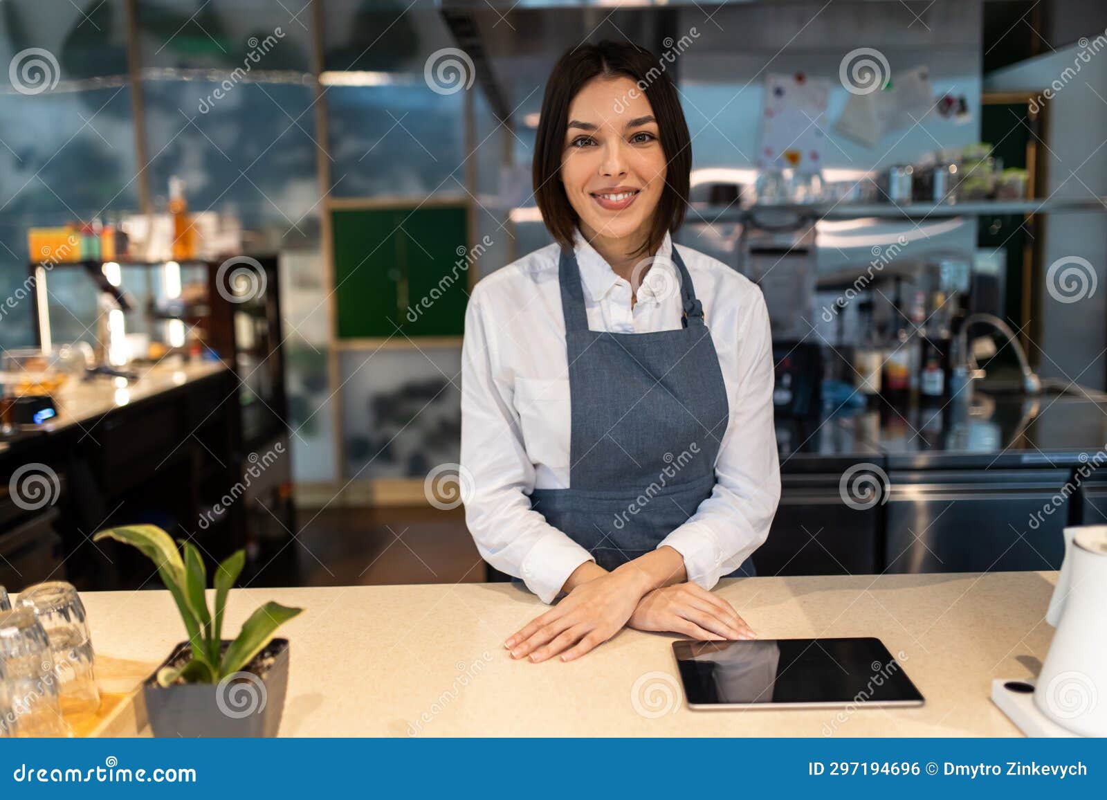 Cute Dark-haired Coffee Shop Assistant with a Tablet in Hand Smiling ...